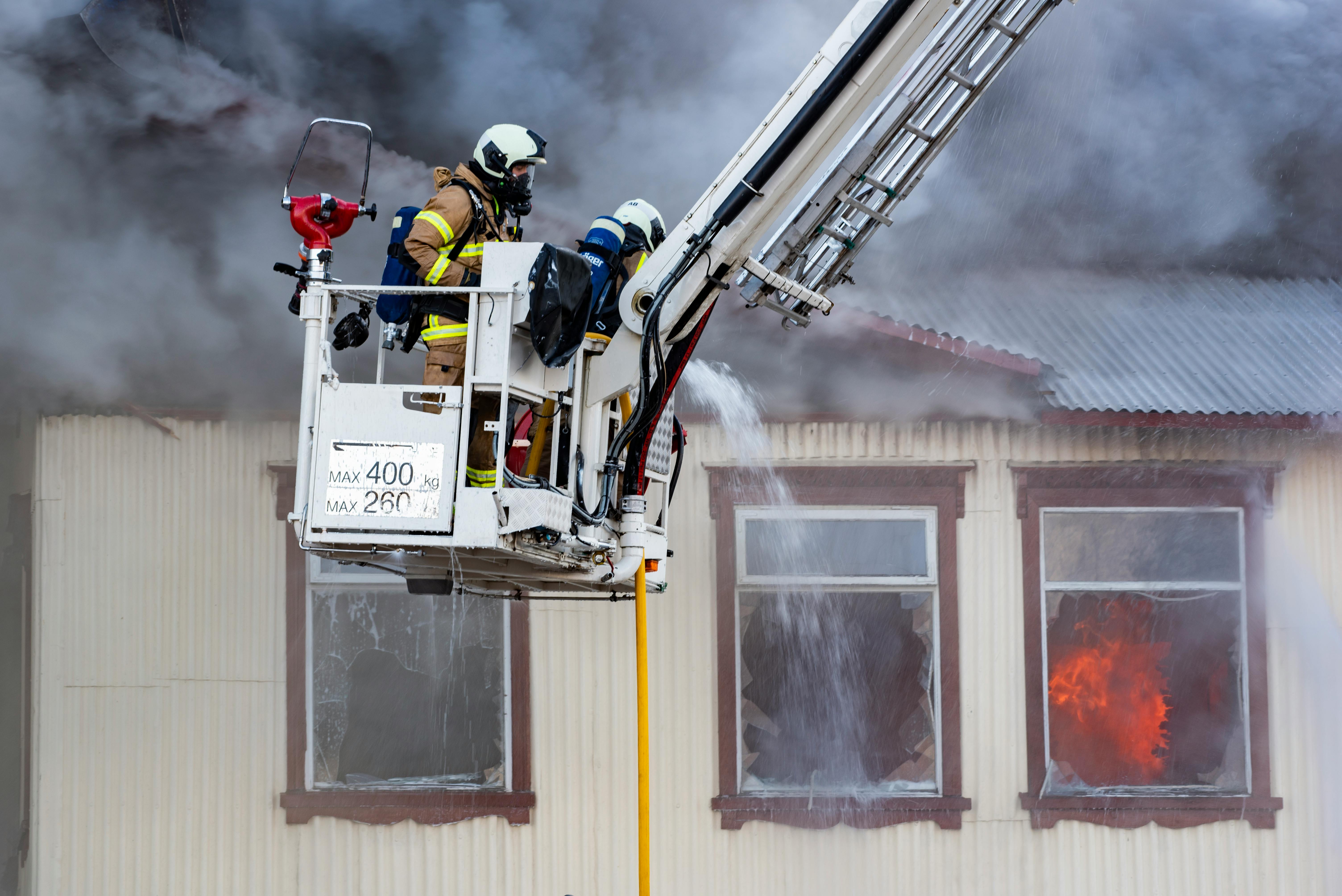 Firefighters Battling Blaze on Ladder · Free Stock Photo