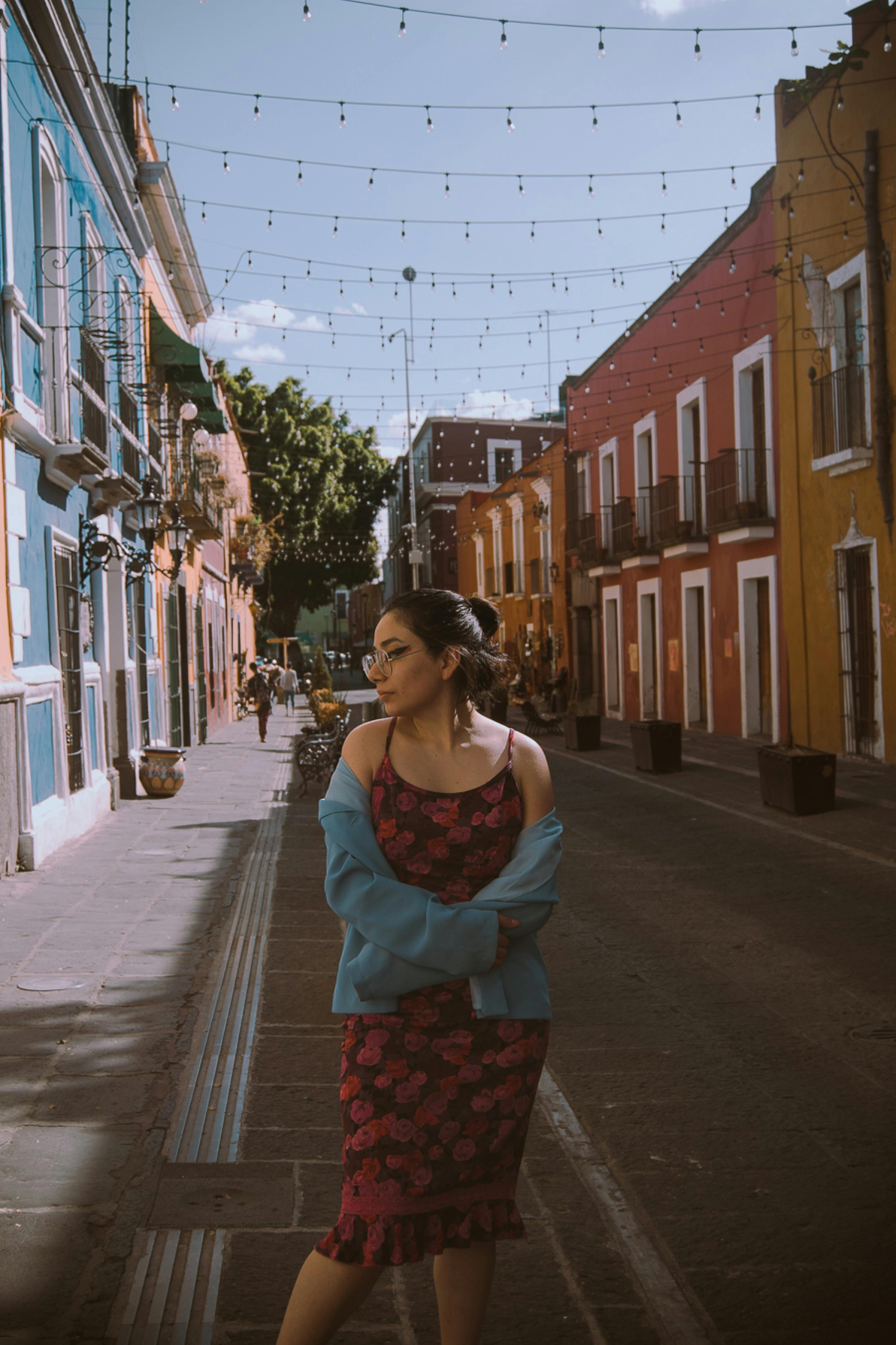 Woman in Vibrant Alley with String Lights · Free Stock Photo