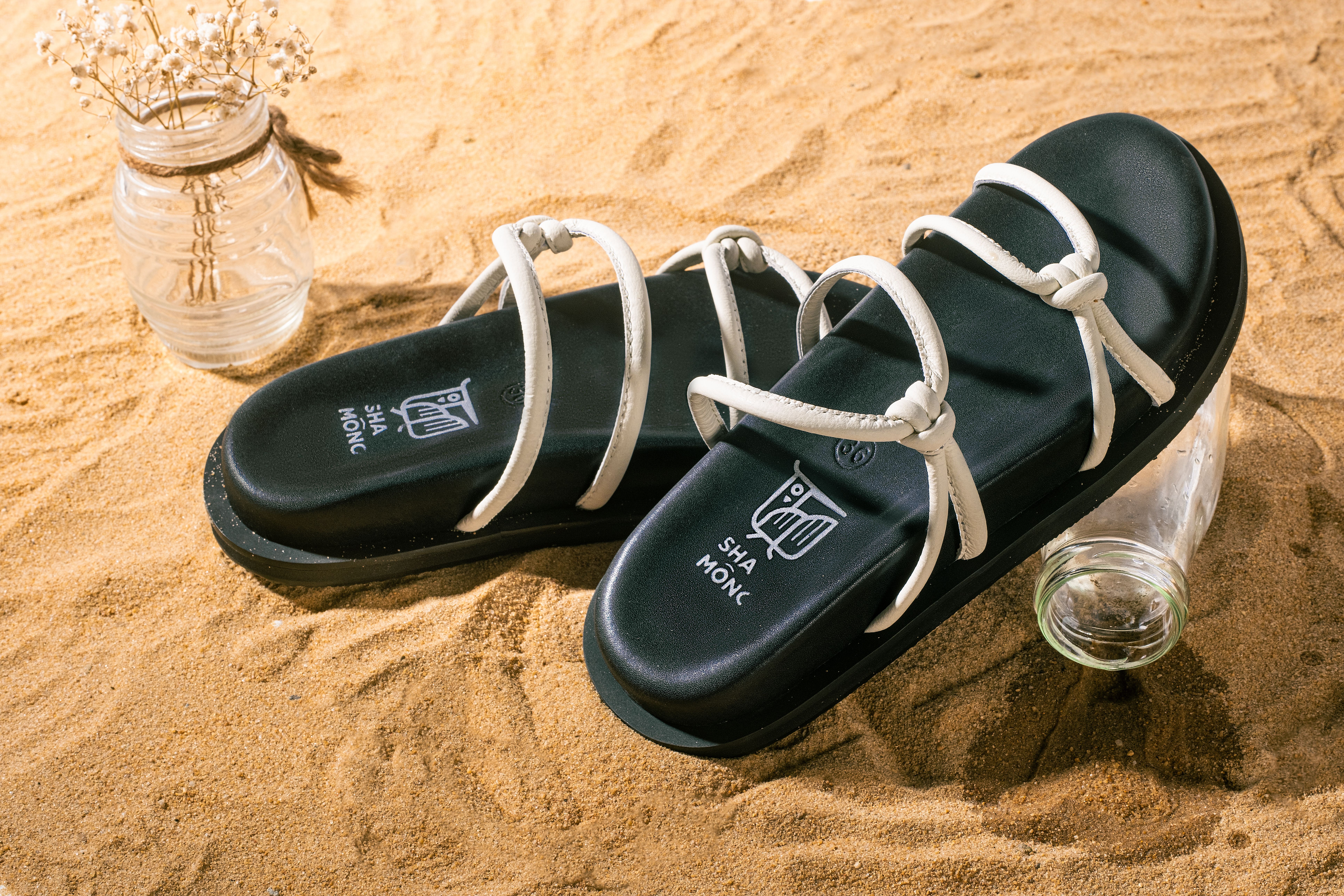 Stylish Black Sandals on a Sandy Beach · Free Stock Photo