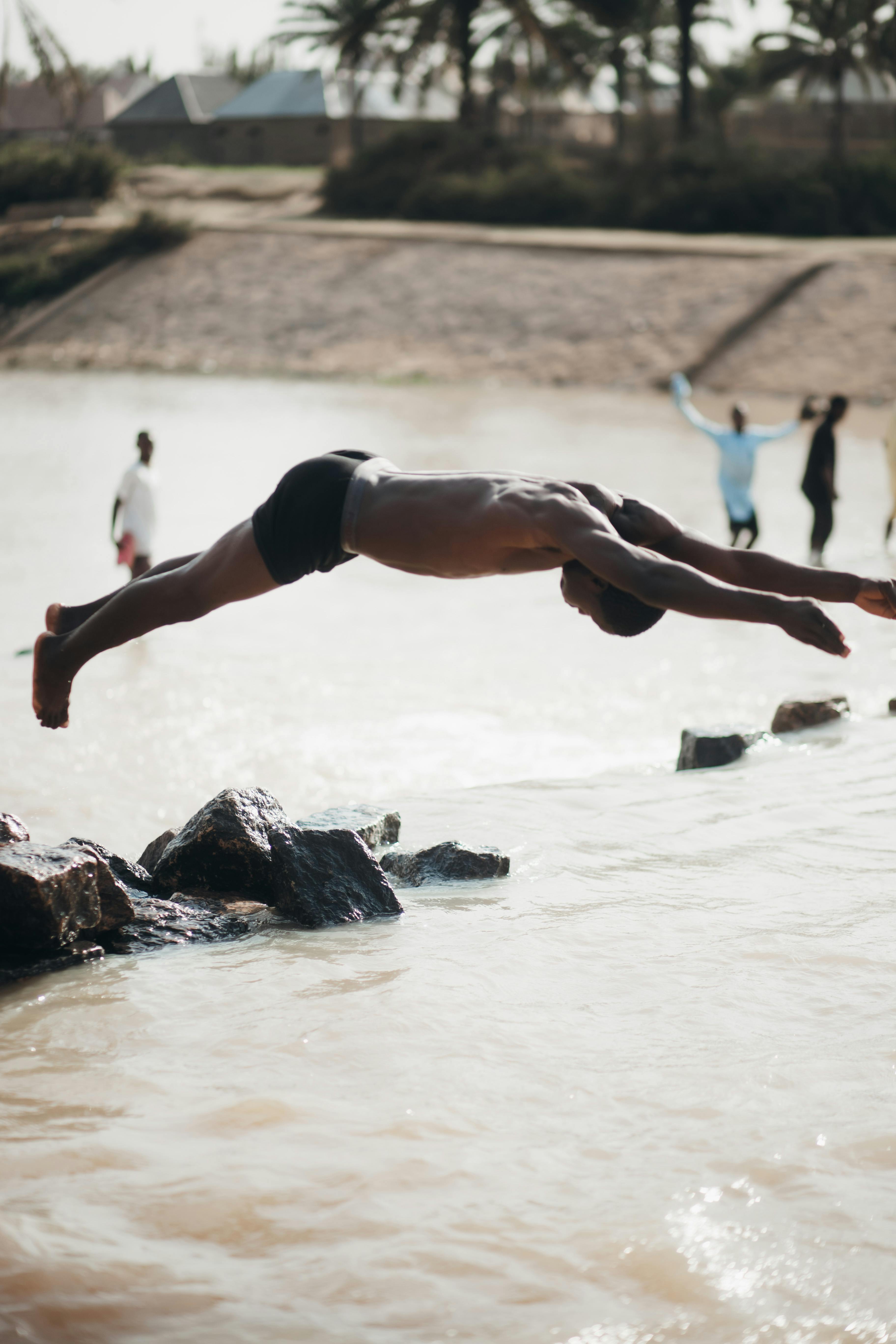 Young Man Diving into River on a Sunny Day · Free Stock Photo