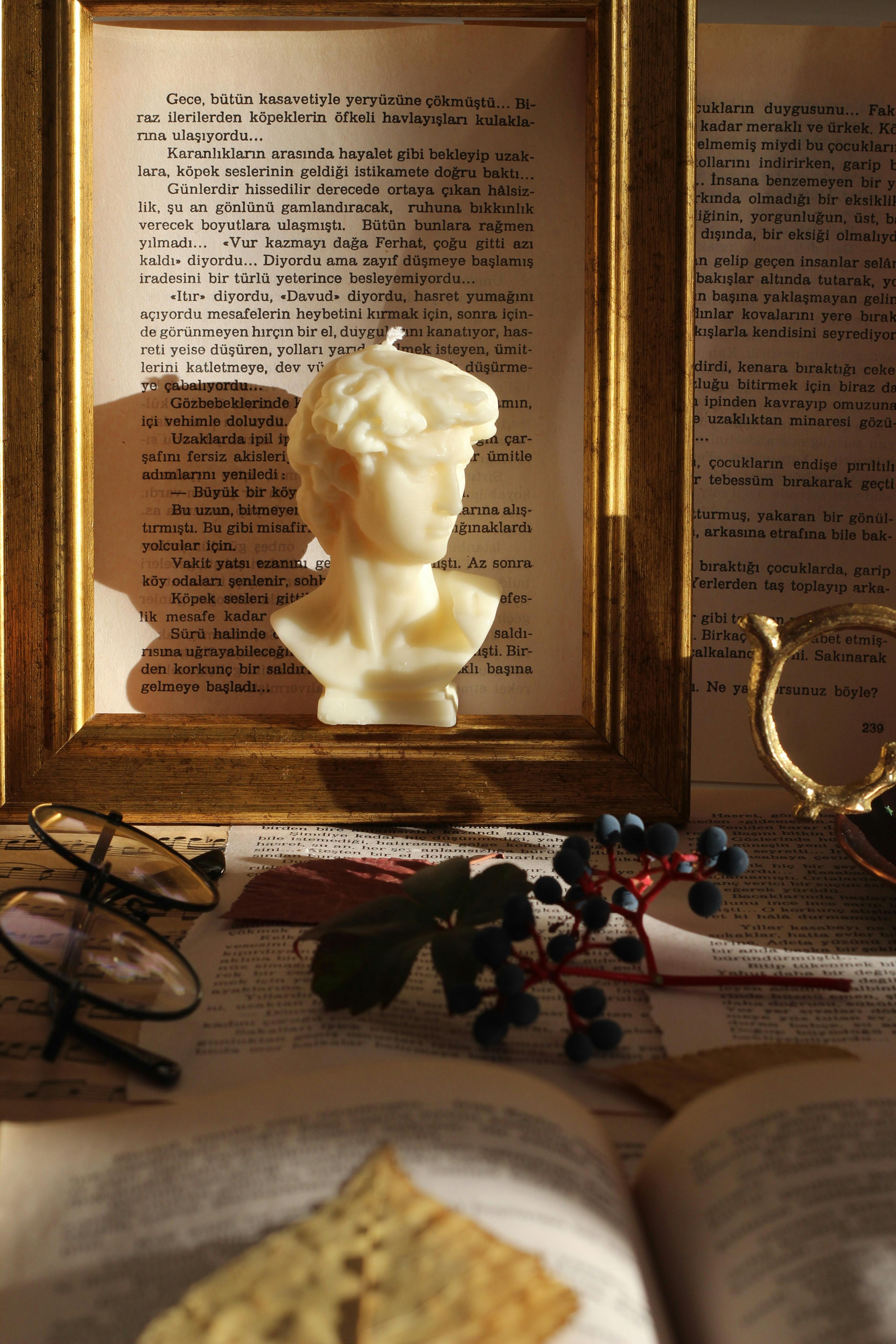 Patung Dada Dan Buku Klasik Di Bawah Sinar Matahari Yang Hangat · Foto ...