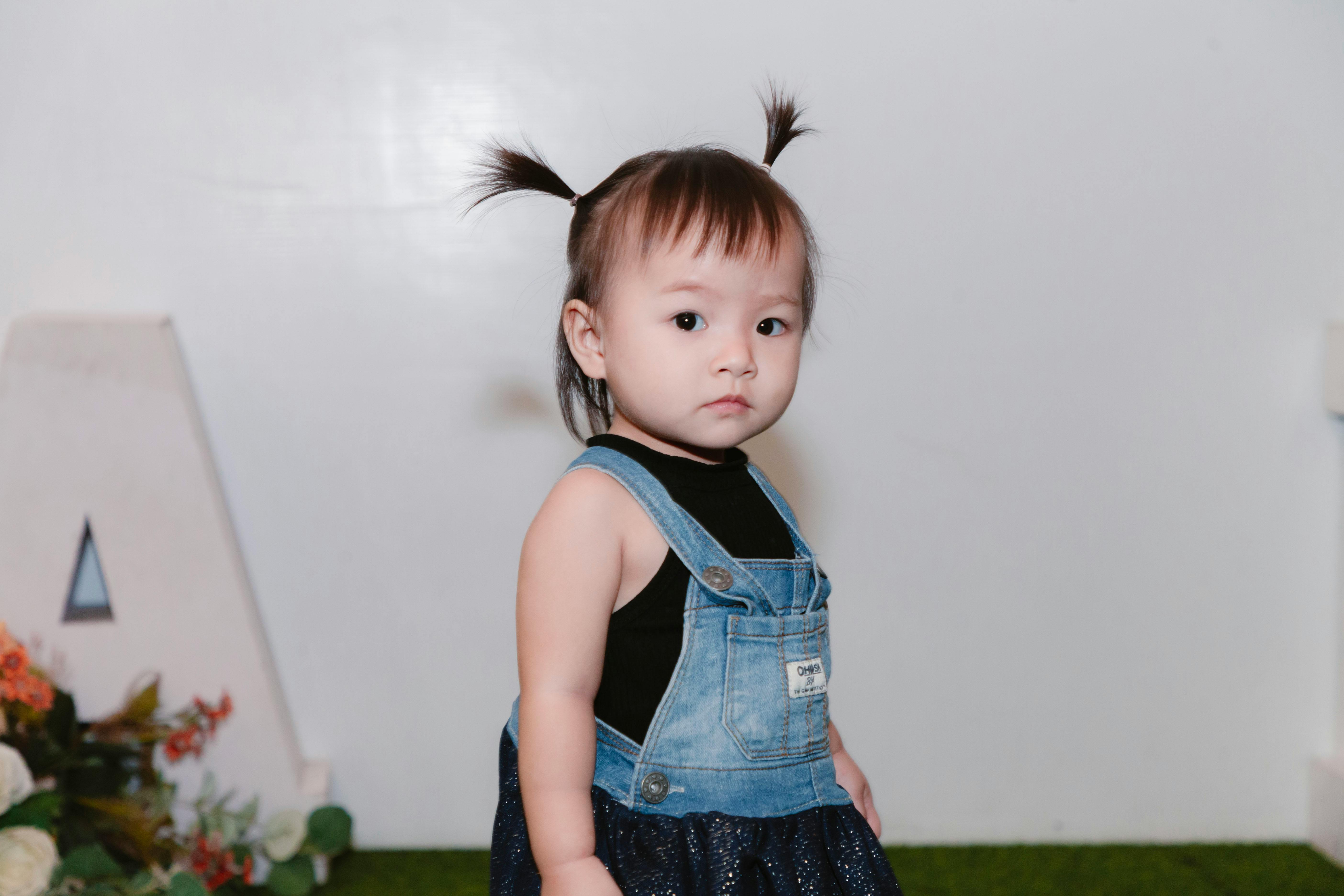 Cute Toddler in Denim Dress at Indoor Setting · Free Stock Photo