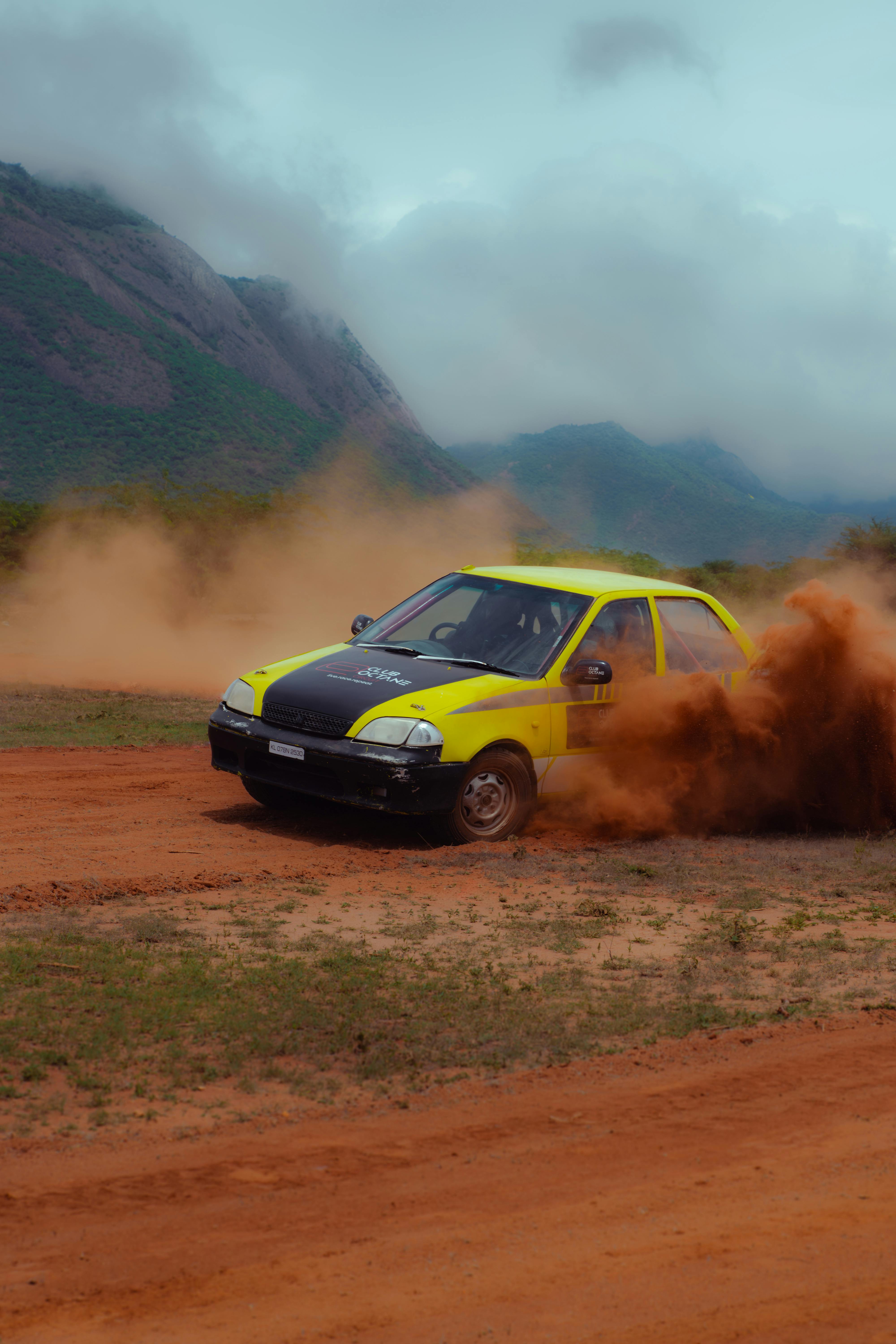 Dynamic Yellow Car Racing on Dusty Terrain · Free Stock Photo