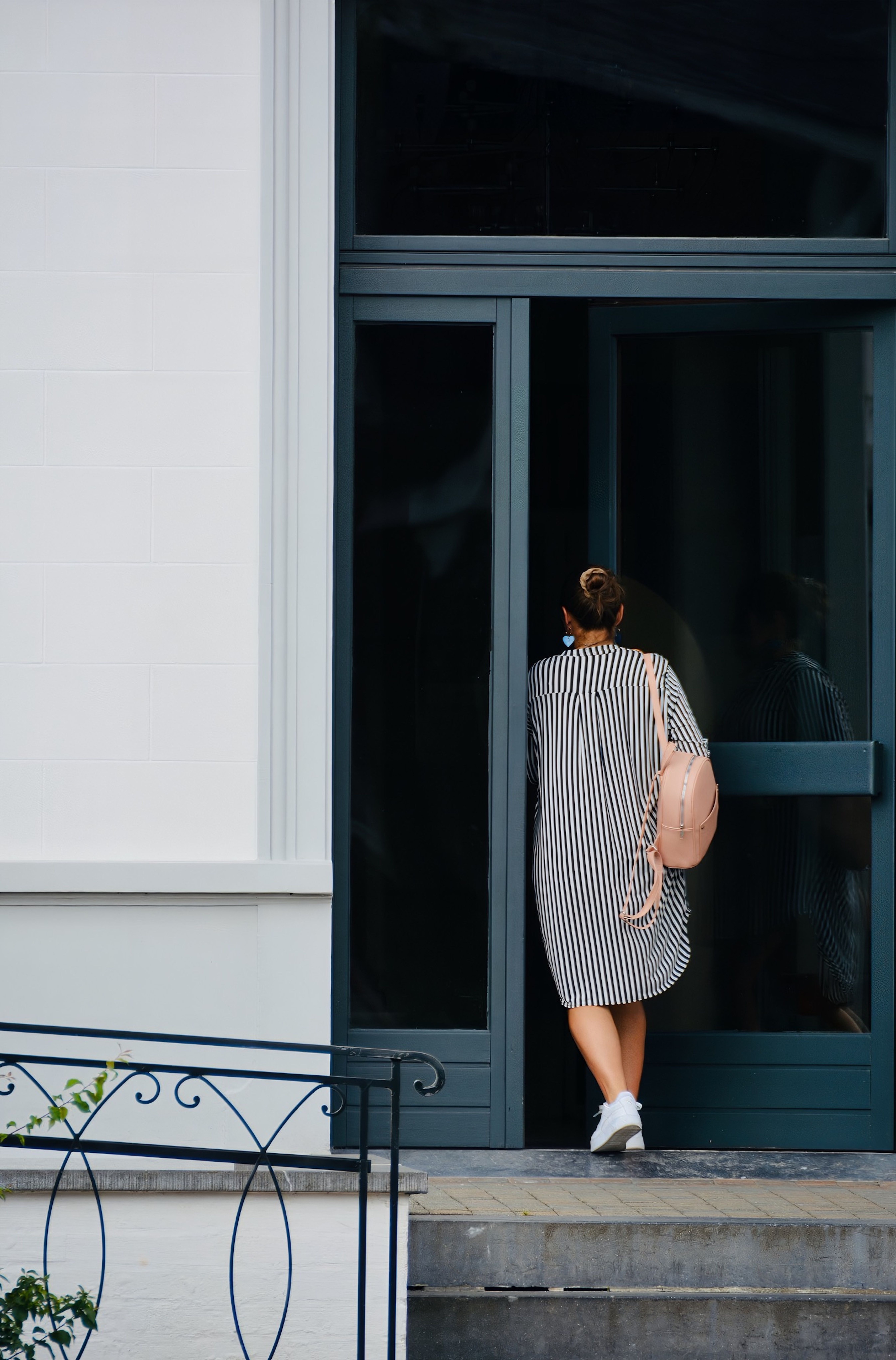 Woman Entering Modern Glass Doorway · Free Stock Photo