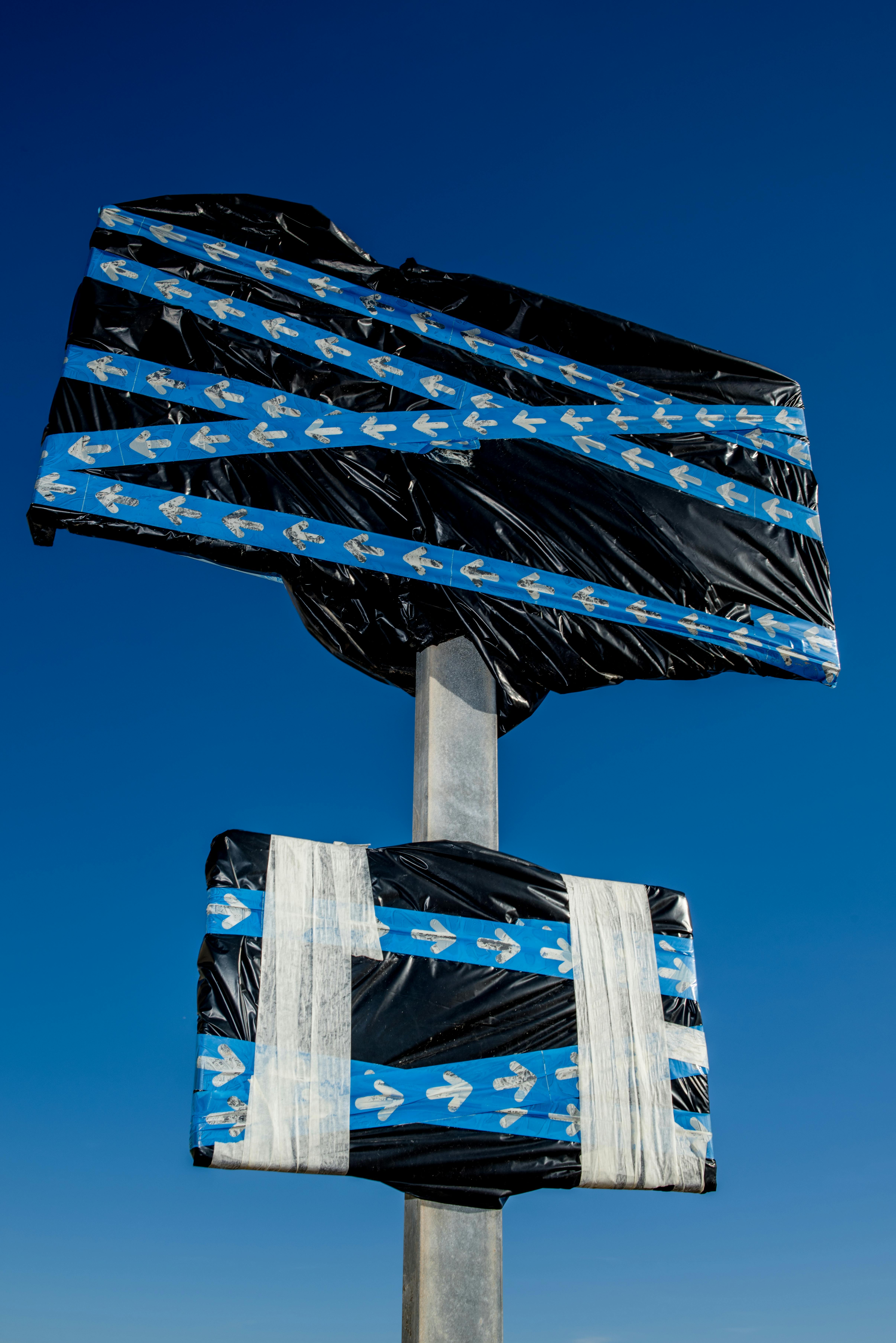 Mystery Road Sign Wrapped in Black and Blue Tape · Free Stock Photo