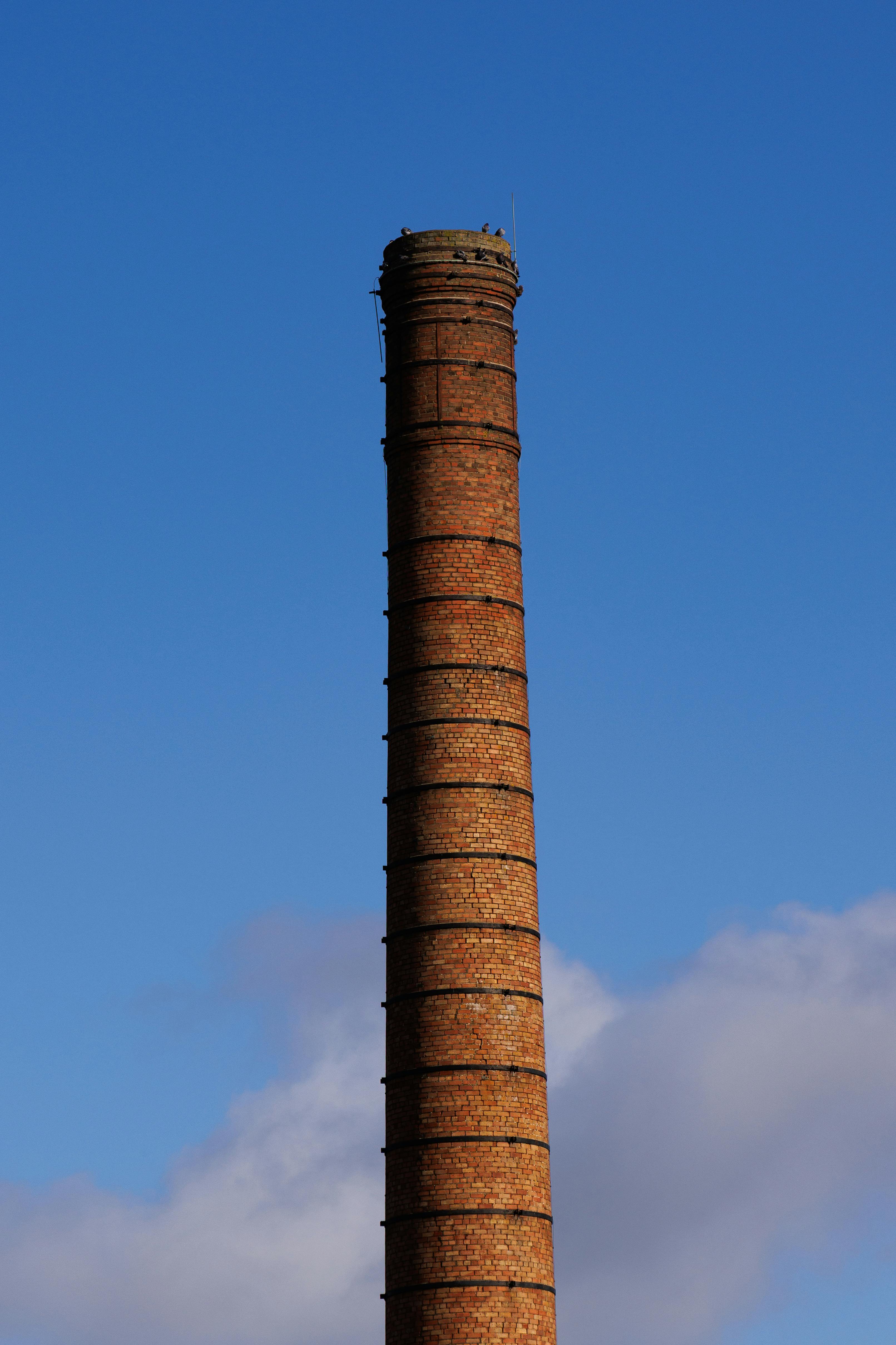 Tall Brick Industrial Chimney Against Blue Sky · Free Stock Photo