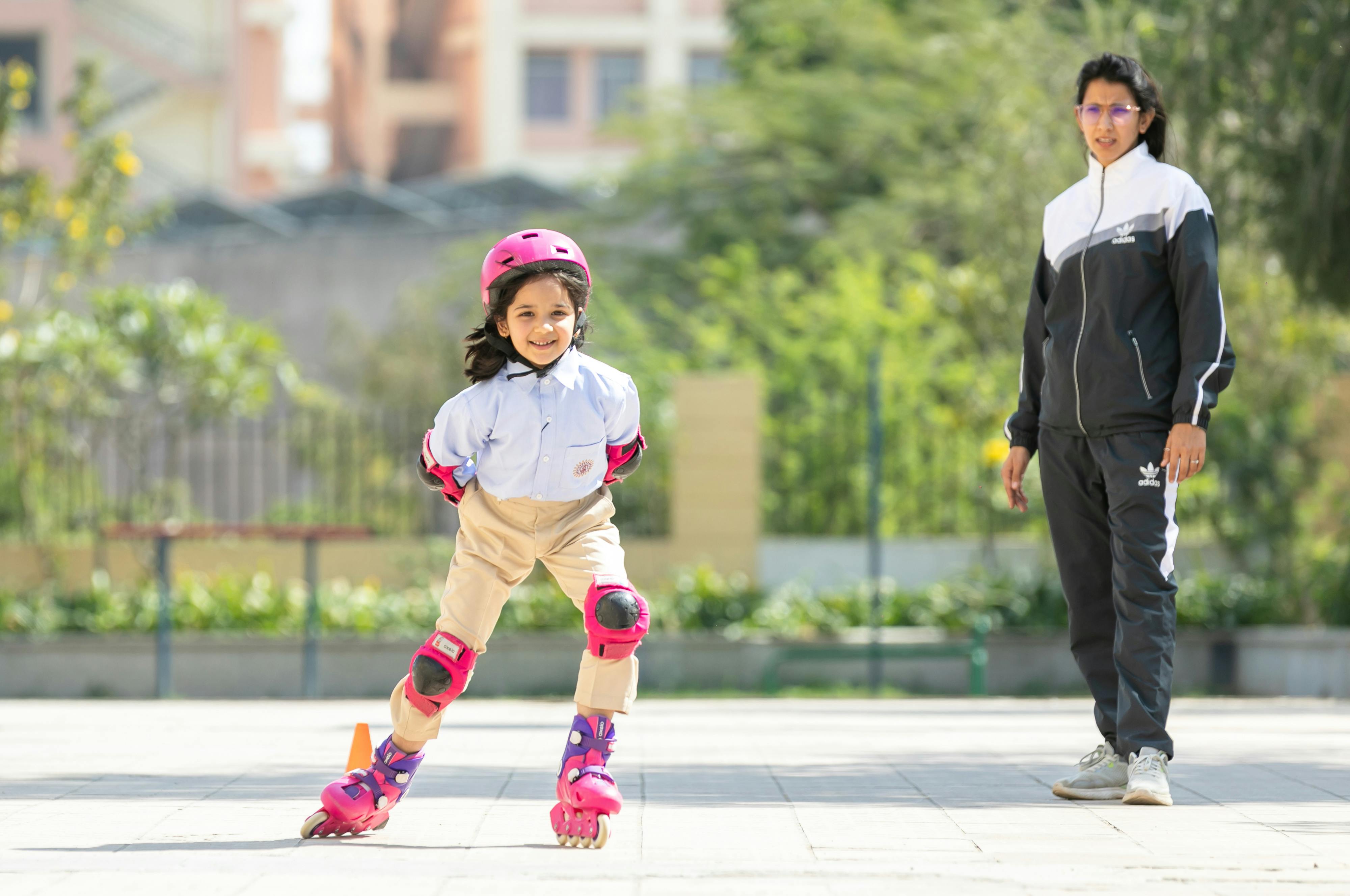 Child Roller Skating with Supervision Outdoors · Free Stock Photo
