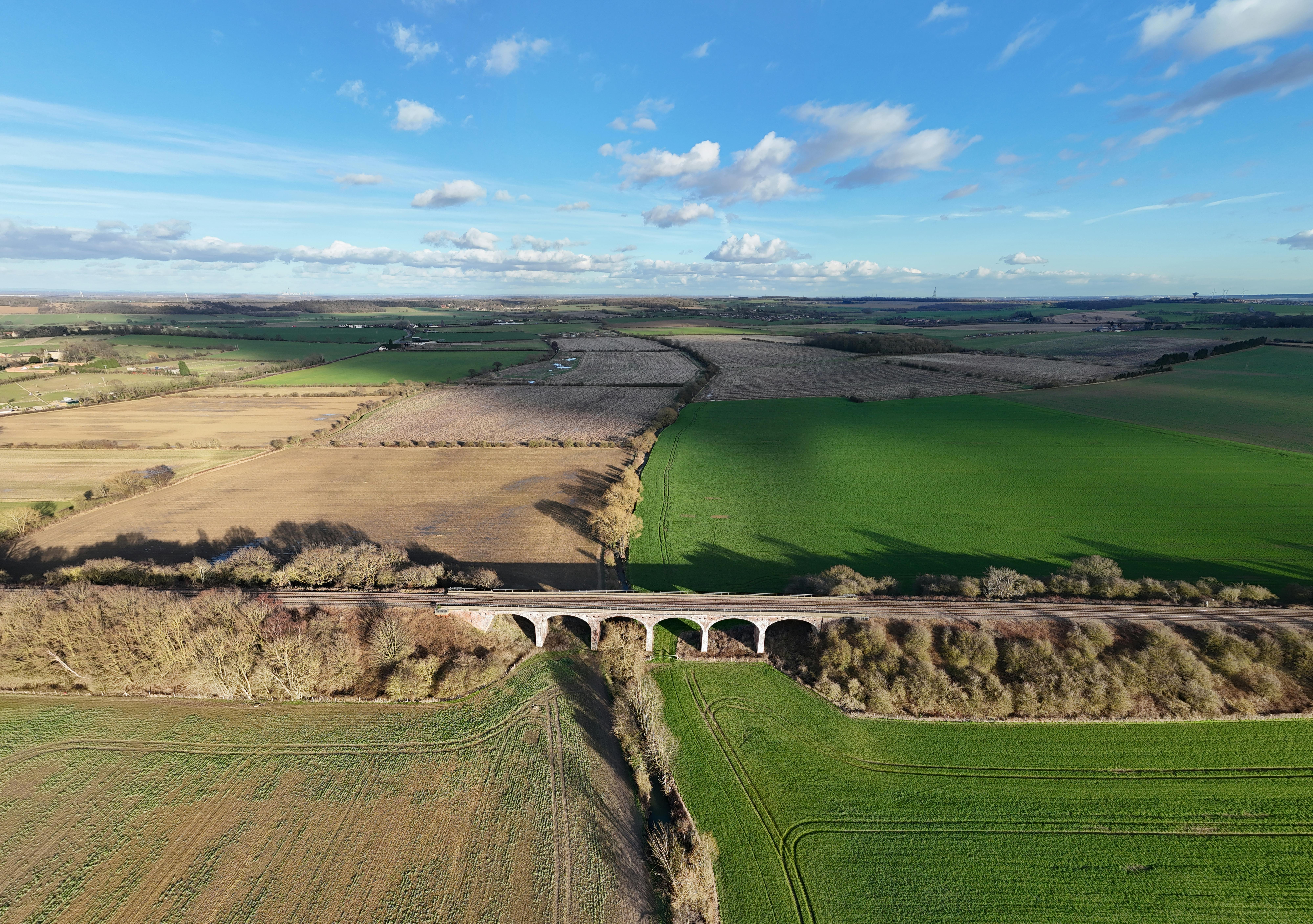 Aerial View of Railway Viaduct in Lush Fields · Free Stock Photo