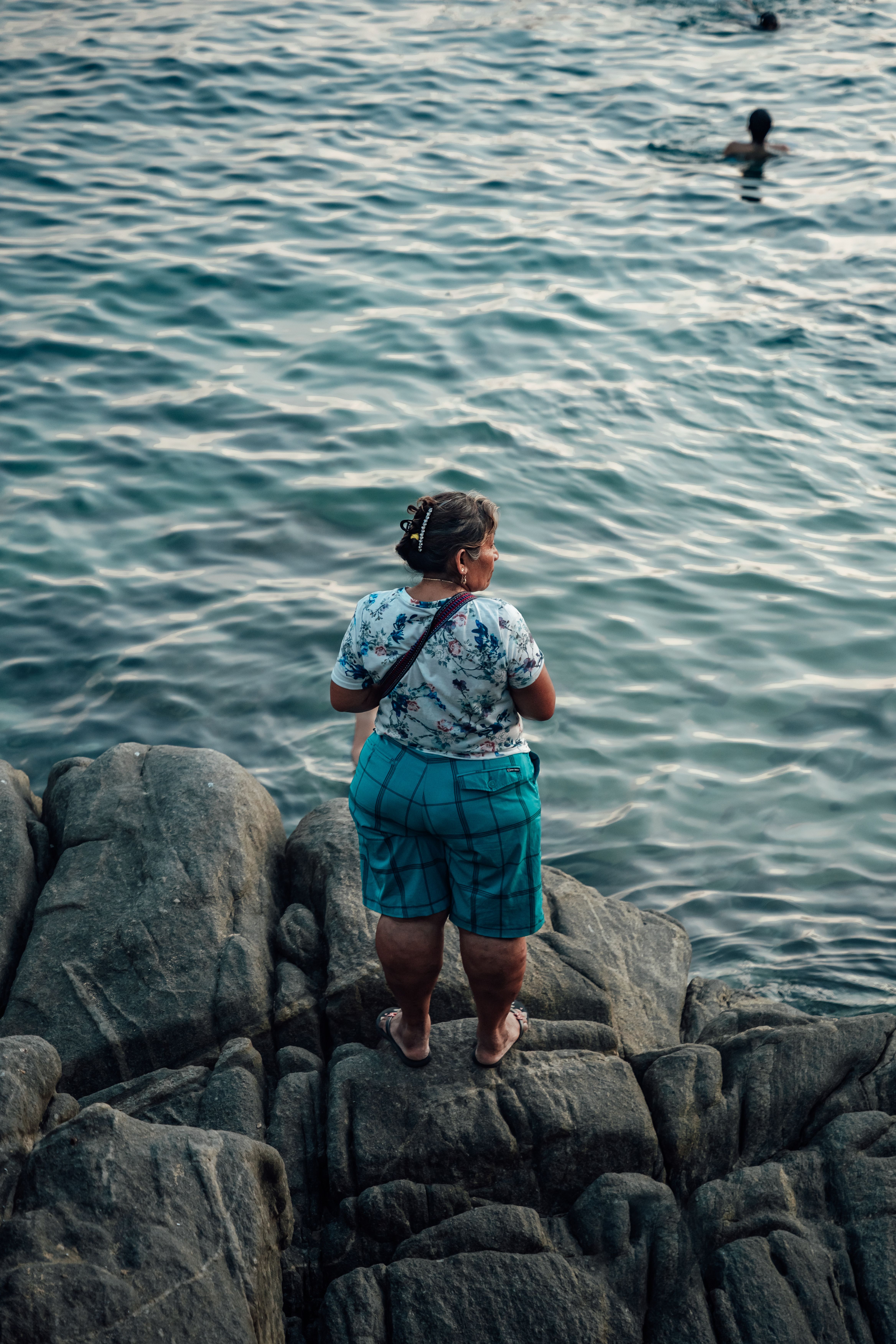 Woman Observing Sea on Rocky Shoreline · Free Stock Photo