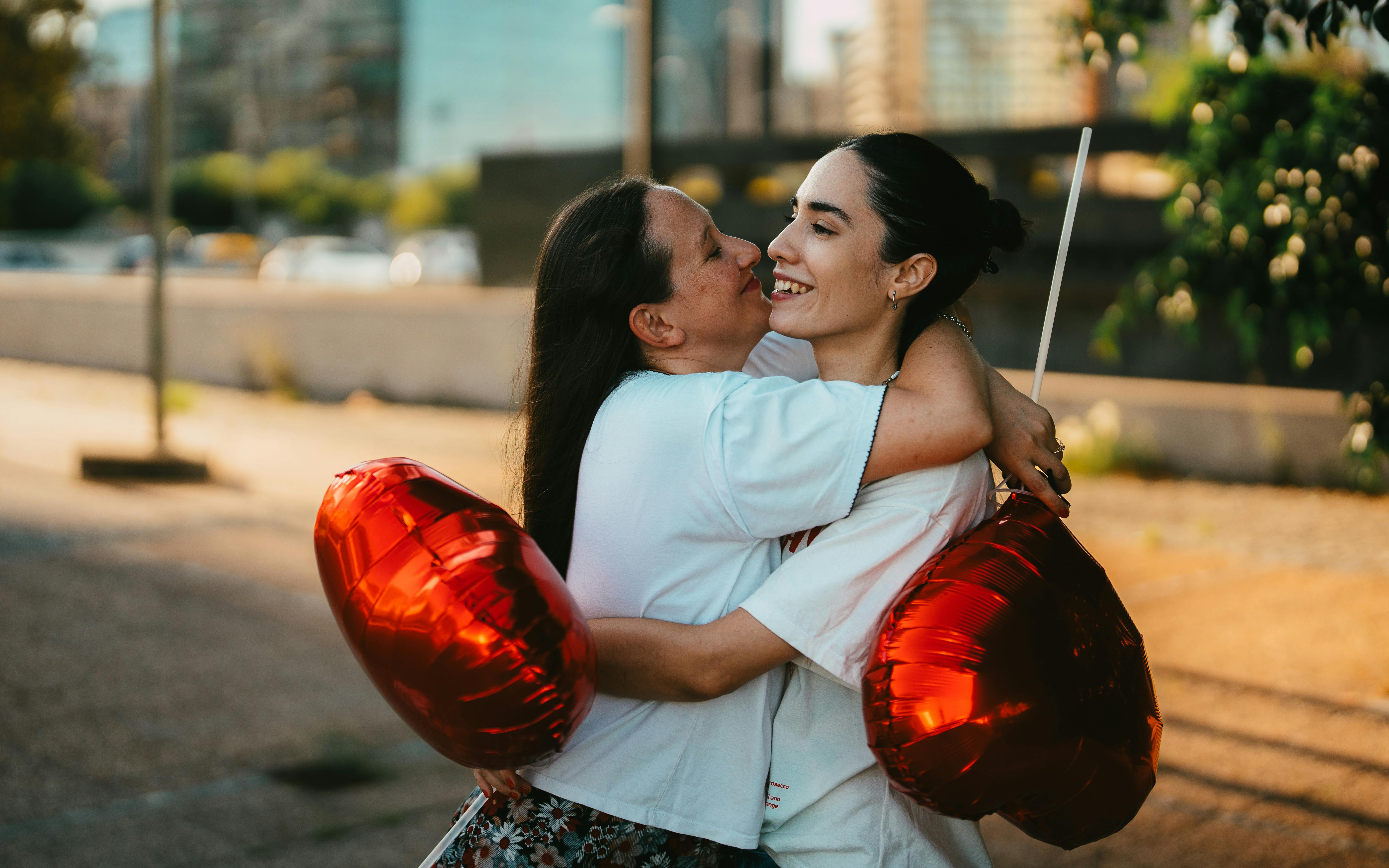 Joyful Hug in Buenos Aires with Heart Balloons · Free Stock Photo