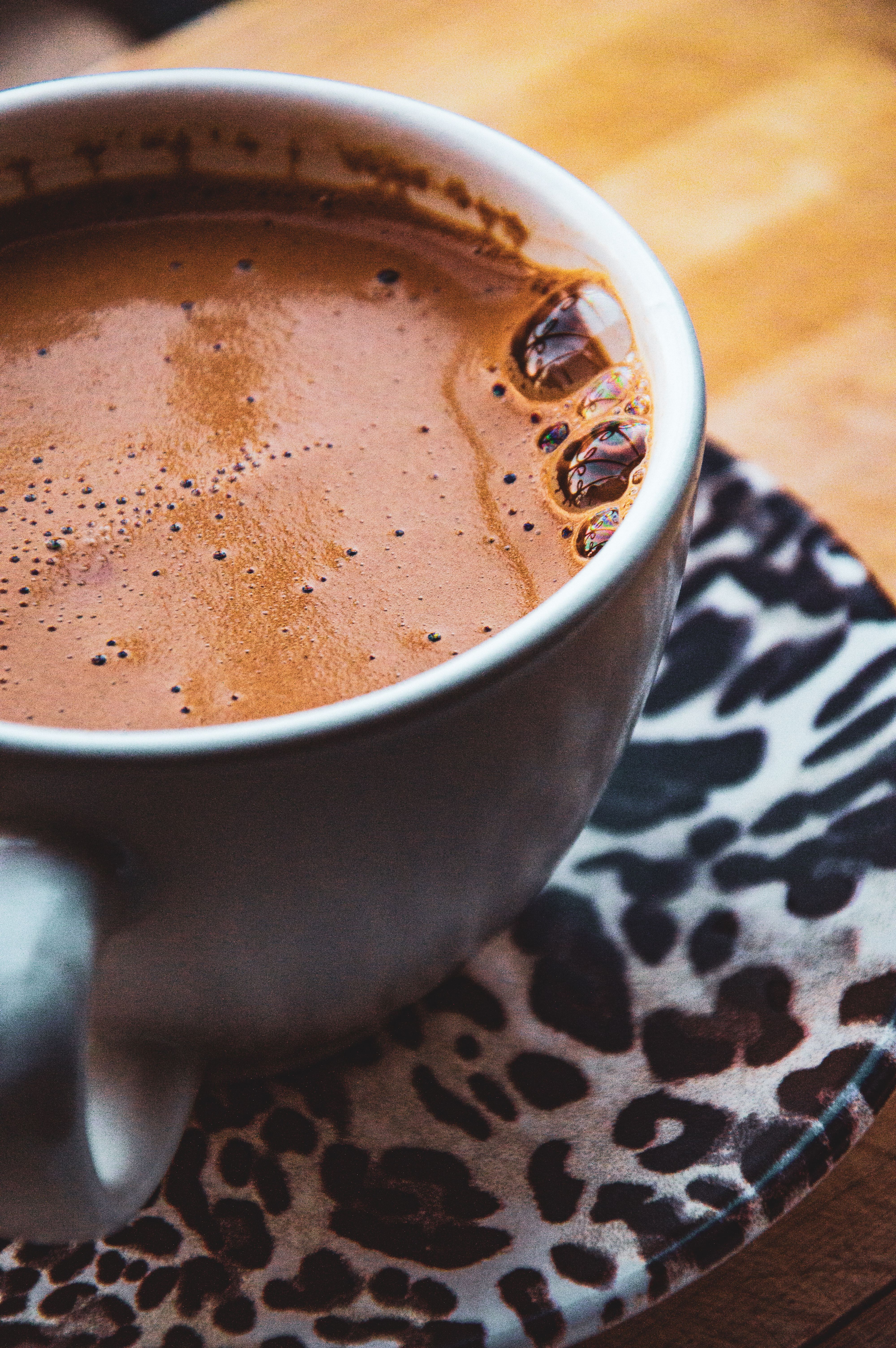 Close-up of Steaming Cup with Animal Print Saucer · Free Stock Photo