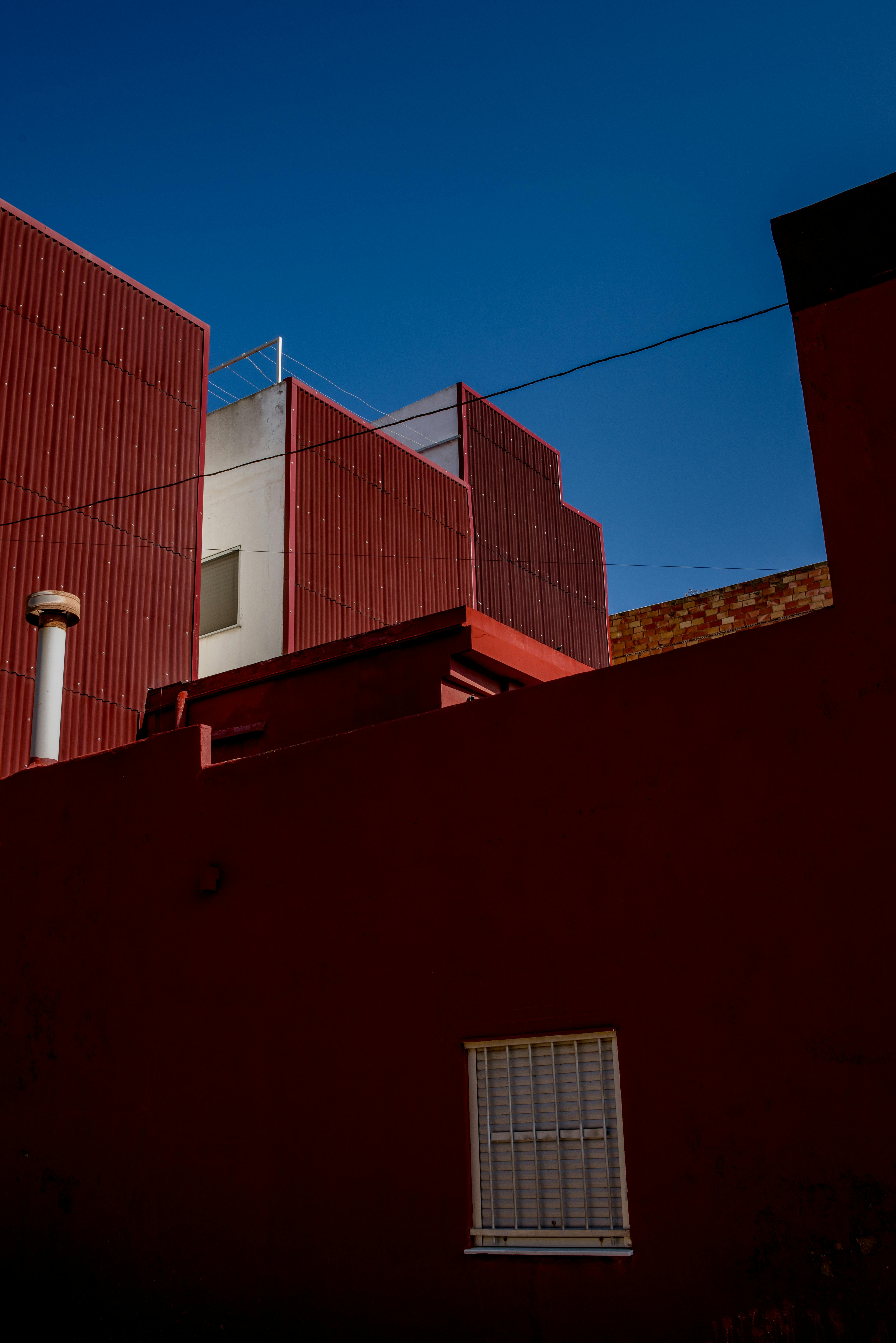 Modern Red Building Against Clear Blue Sky · Free Stock Photo