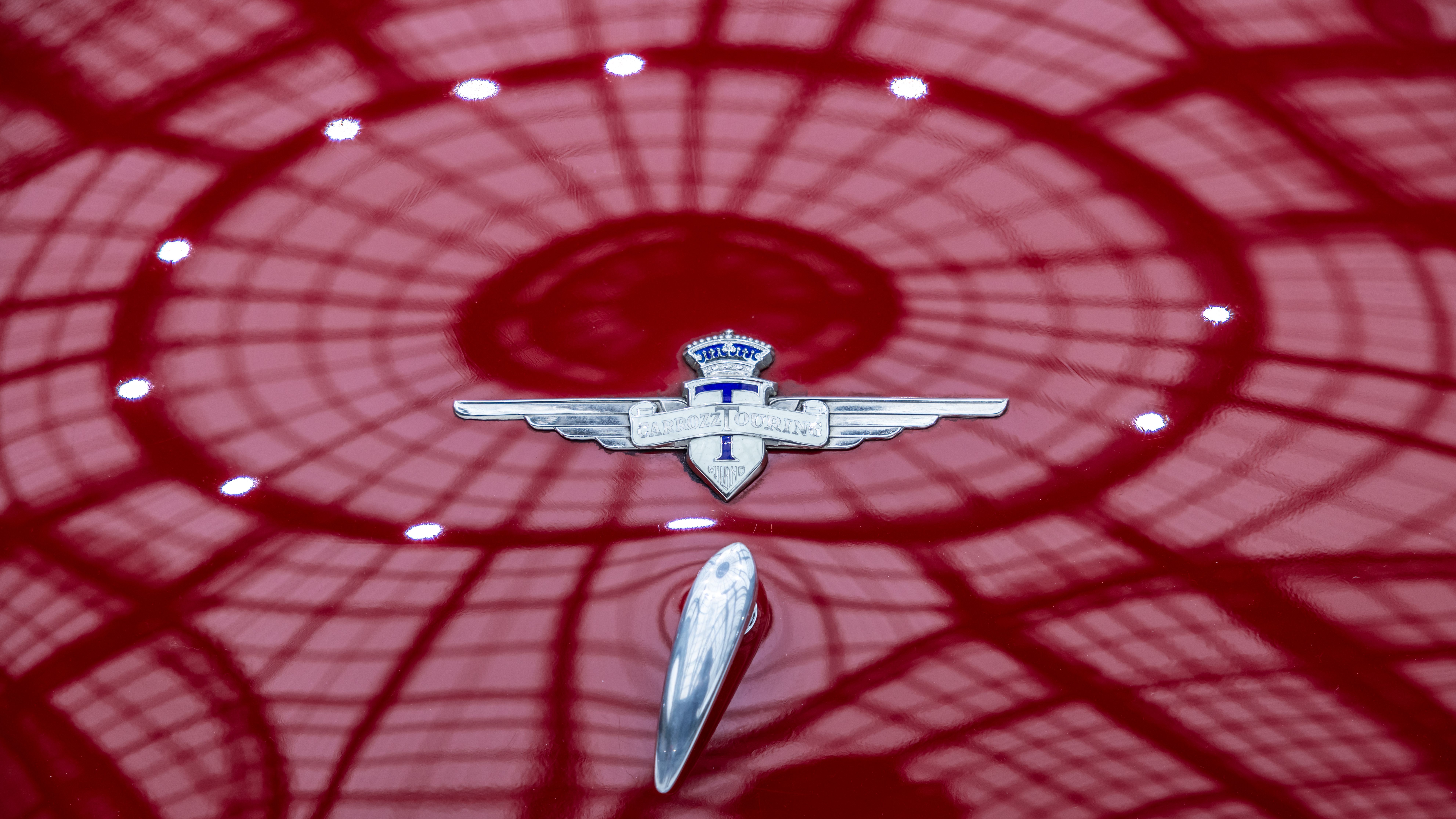 Close-up of classic car emblem on shiny red surface · Free Stock Photo