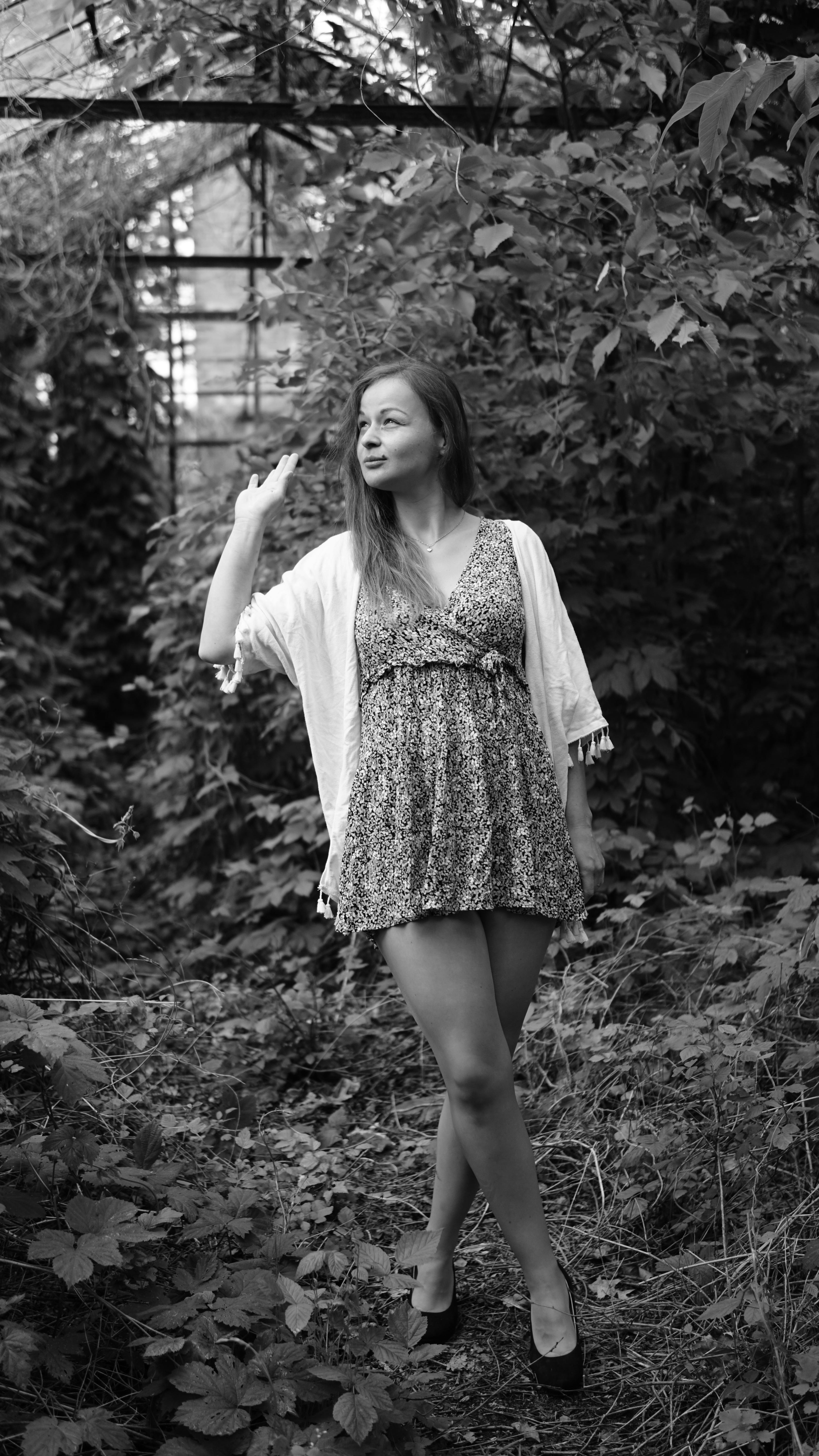 Woman in Floral Dress in Overgrown Greenhouse · Free Stock Photo