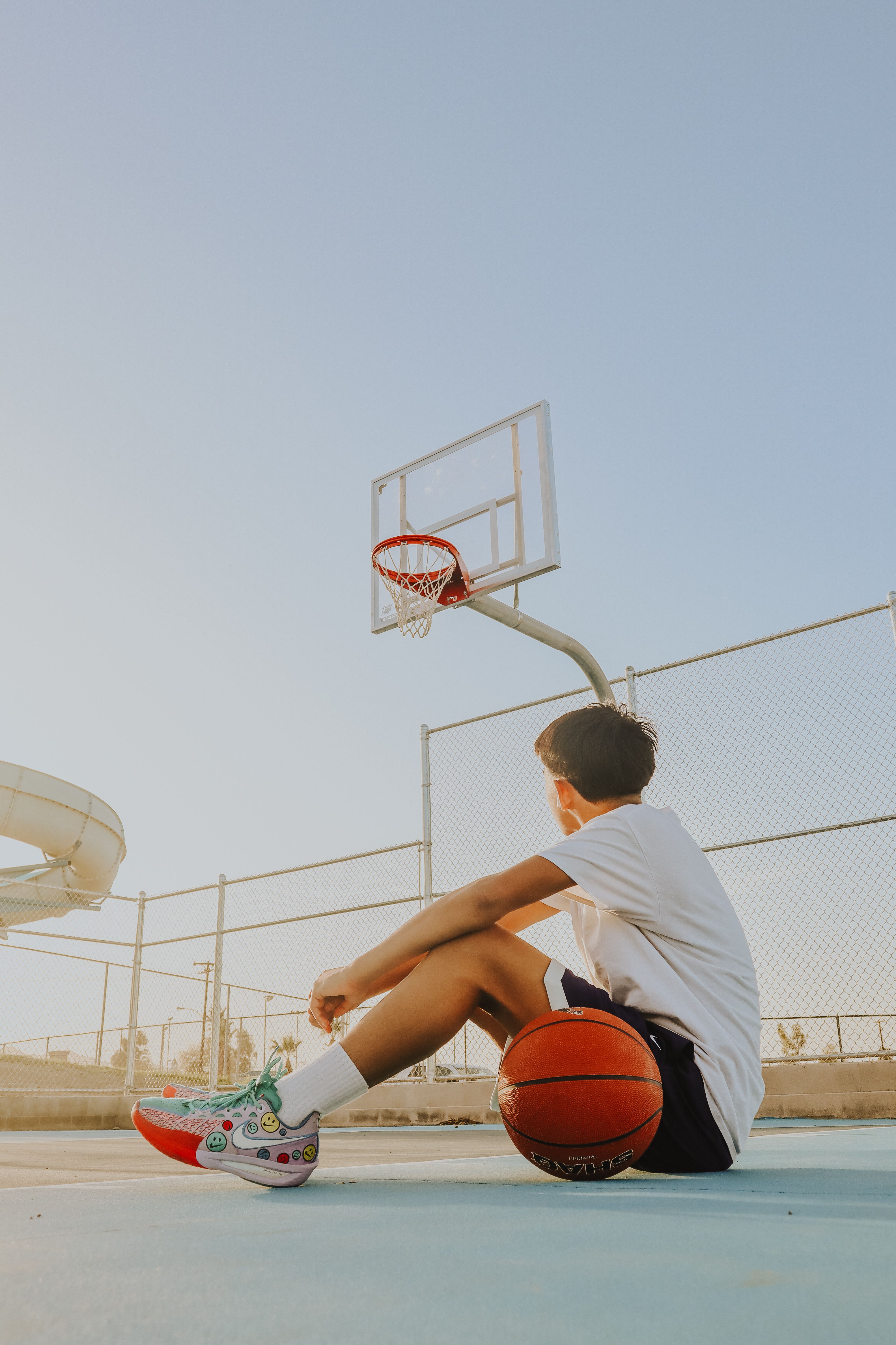 Teenager Reflecting on Outdoor Basketball Court · Free Stock Photo