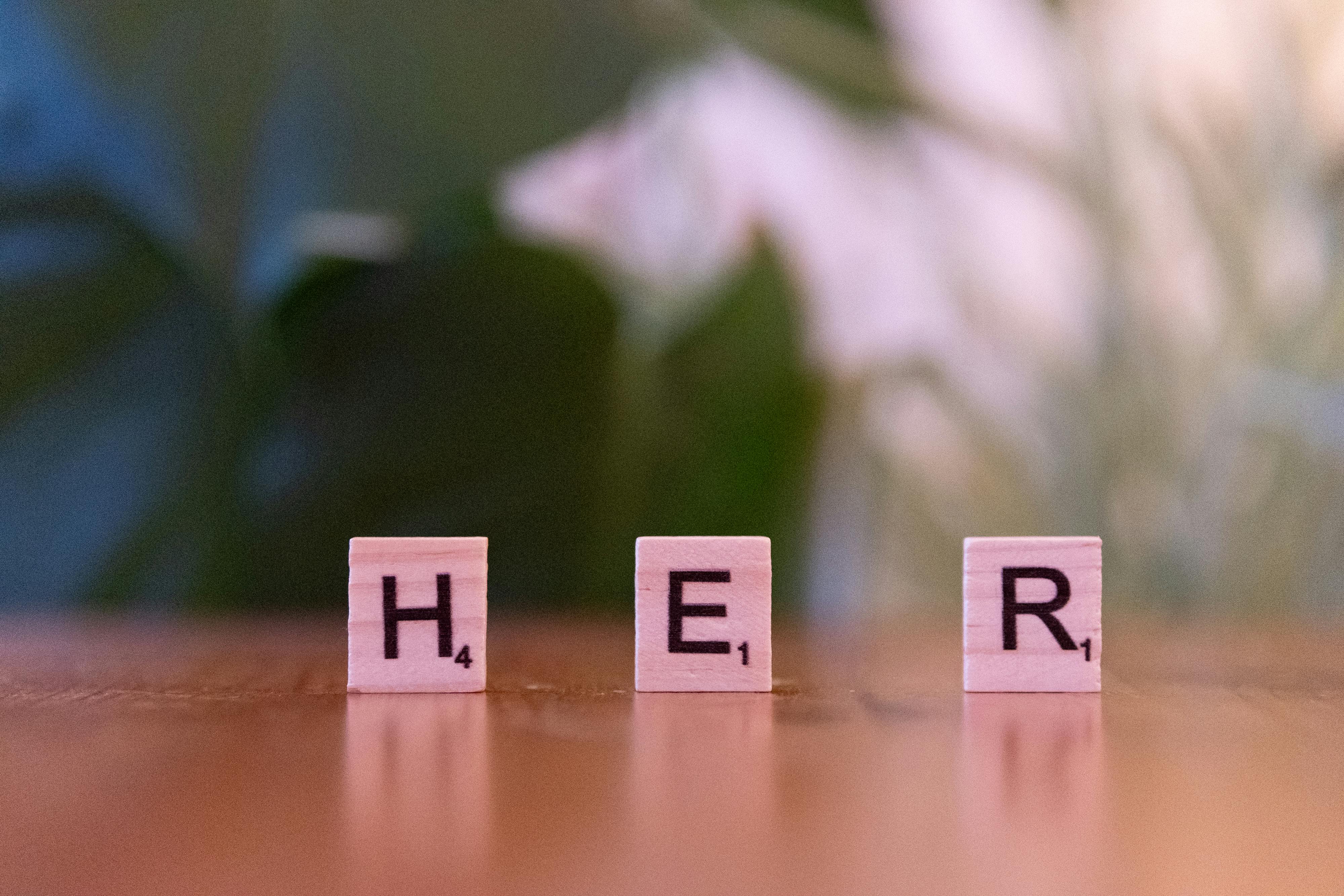Scrabble Tiles Spelling Her on Wooden Table · Free Stock Photo