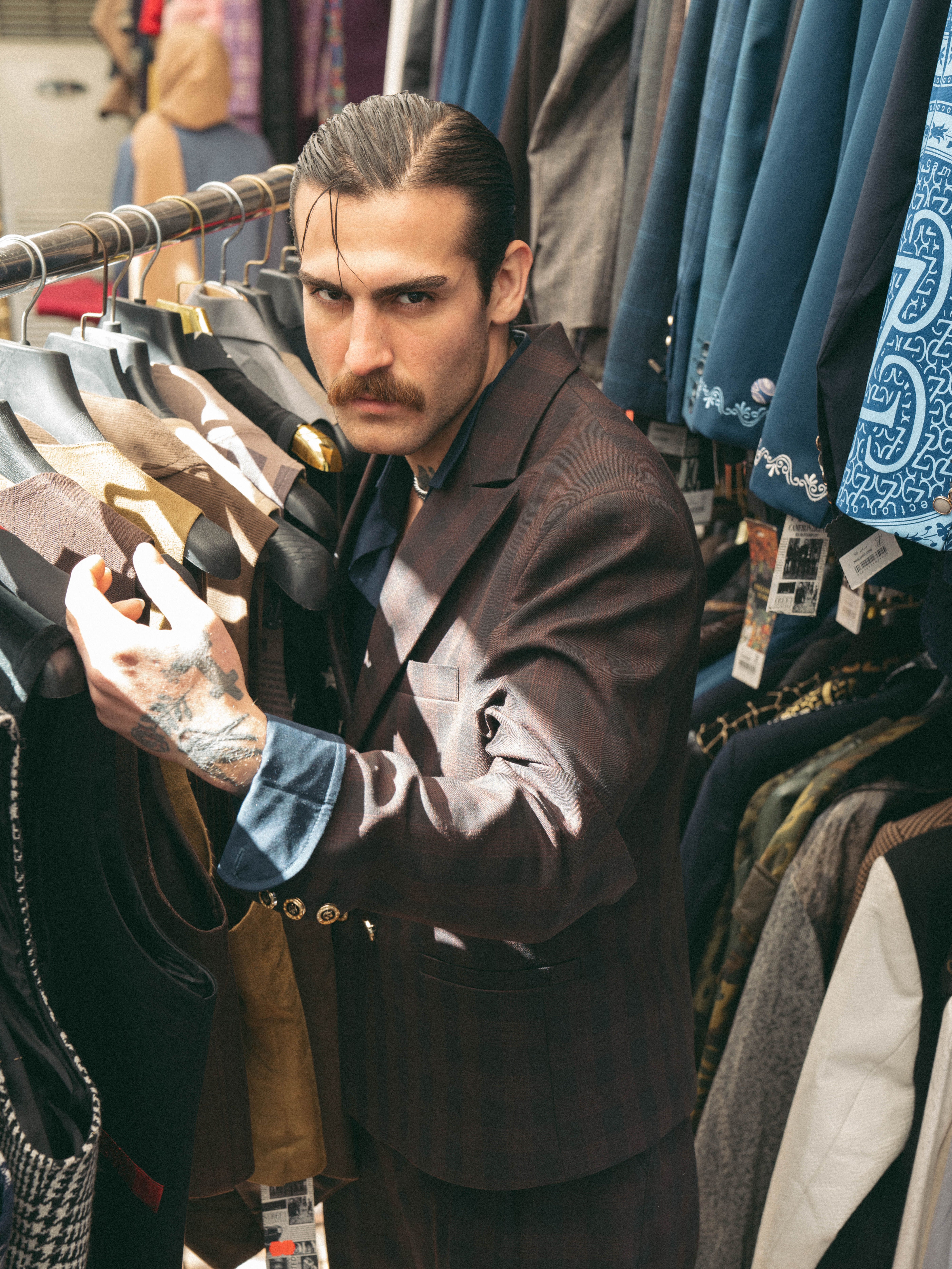 Man Browsing Suits at a Vintage Clothing Store · Free Stock Photo