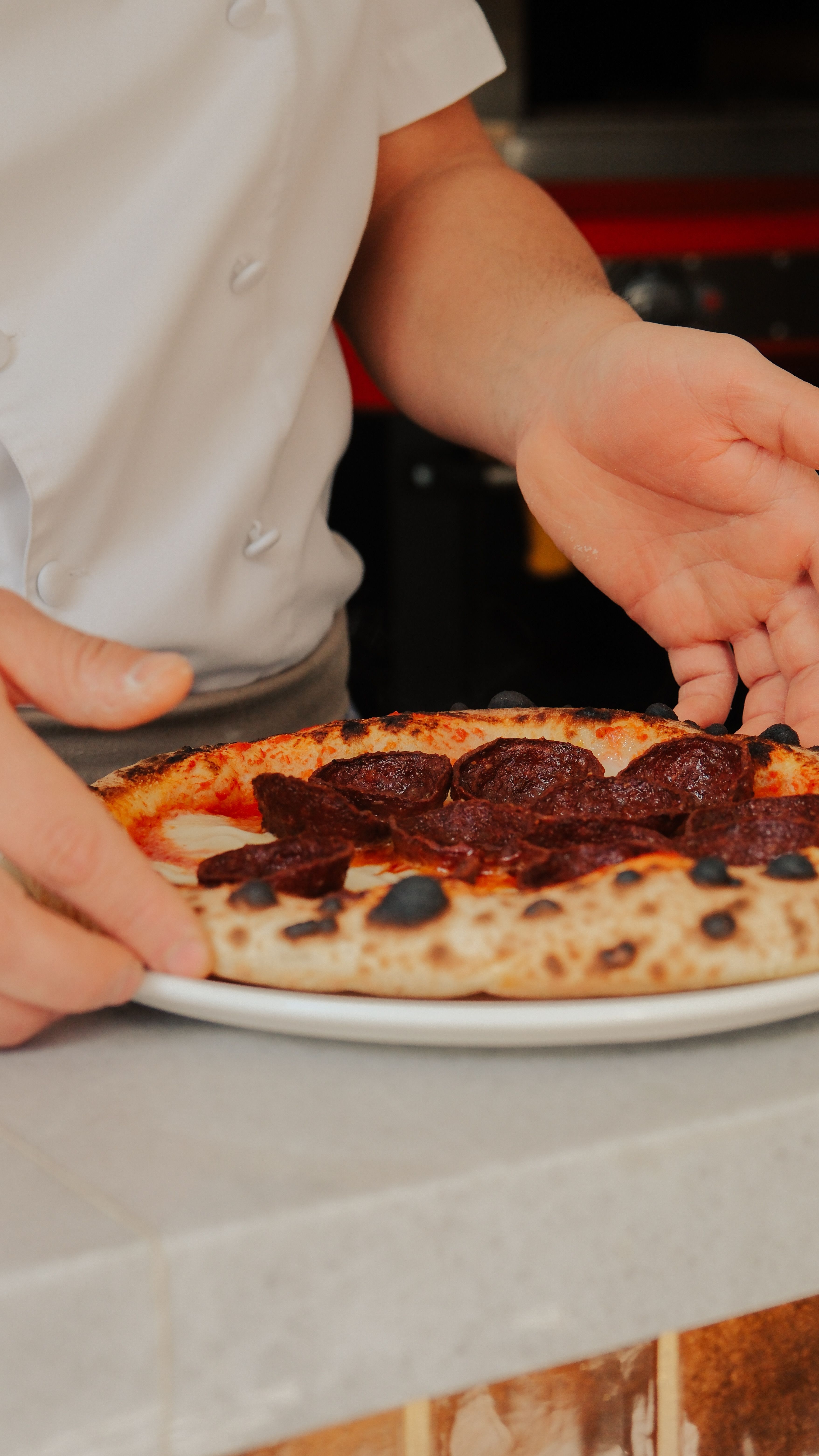 Chef Serving Freshly Baked Pepperoni Pizza · Free Stock Photo