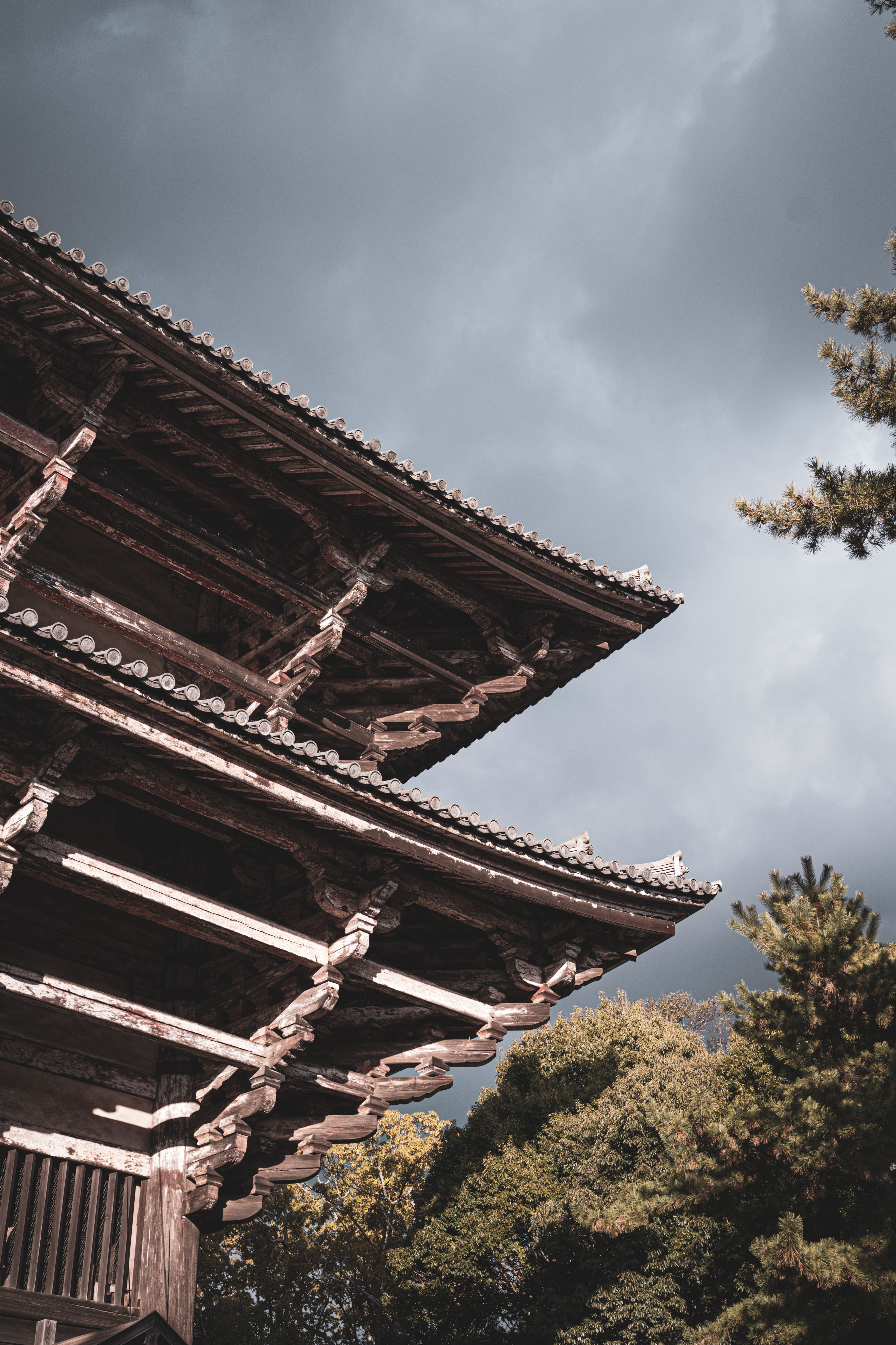 Traditional Japanese Temple Roof Against Cloudy Sky · Free Stock Photo