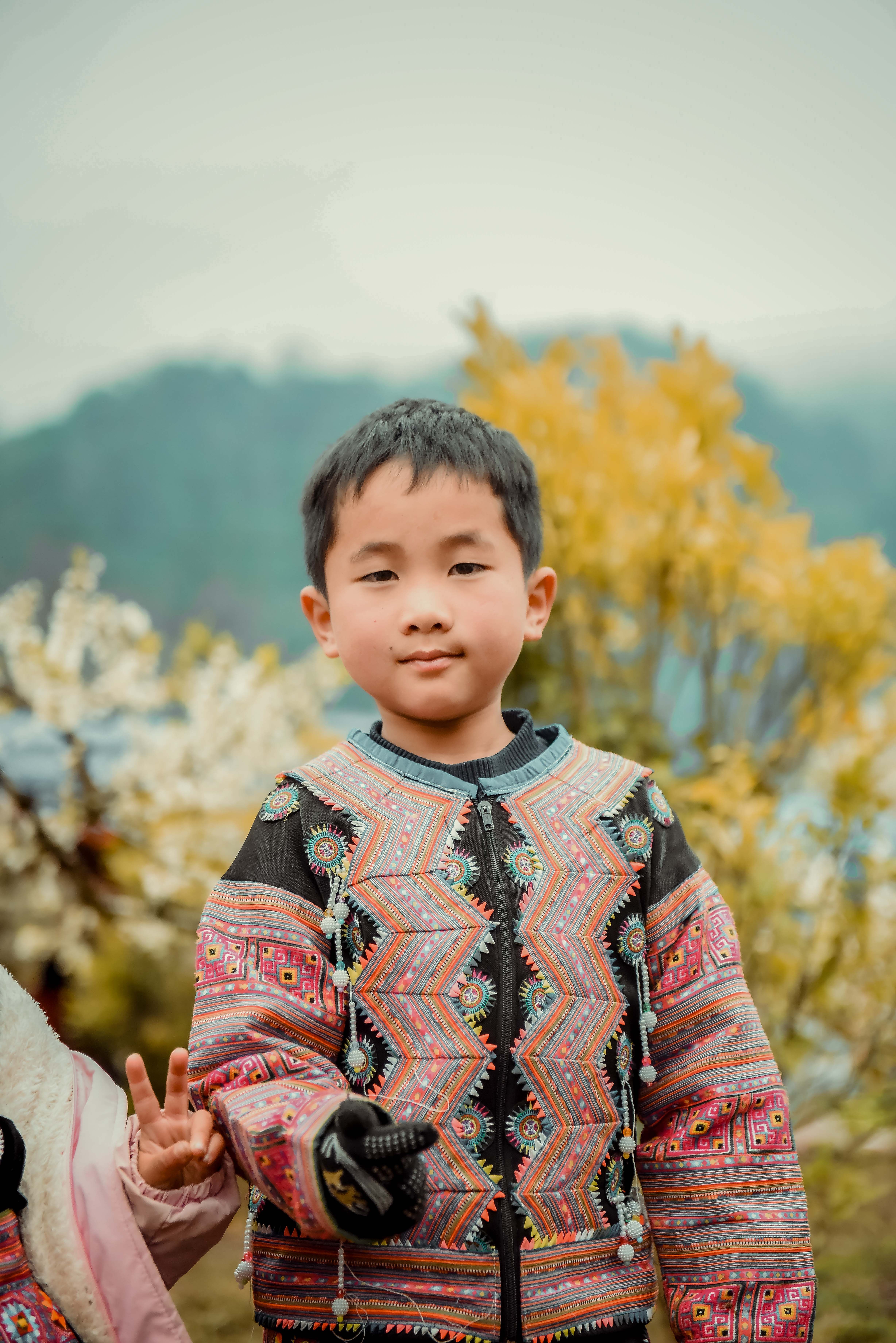 Young boy wearing traditional colorful attire outdoors · Free Stock Photo