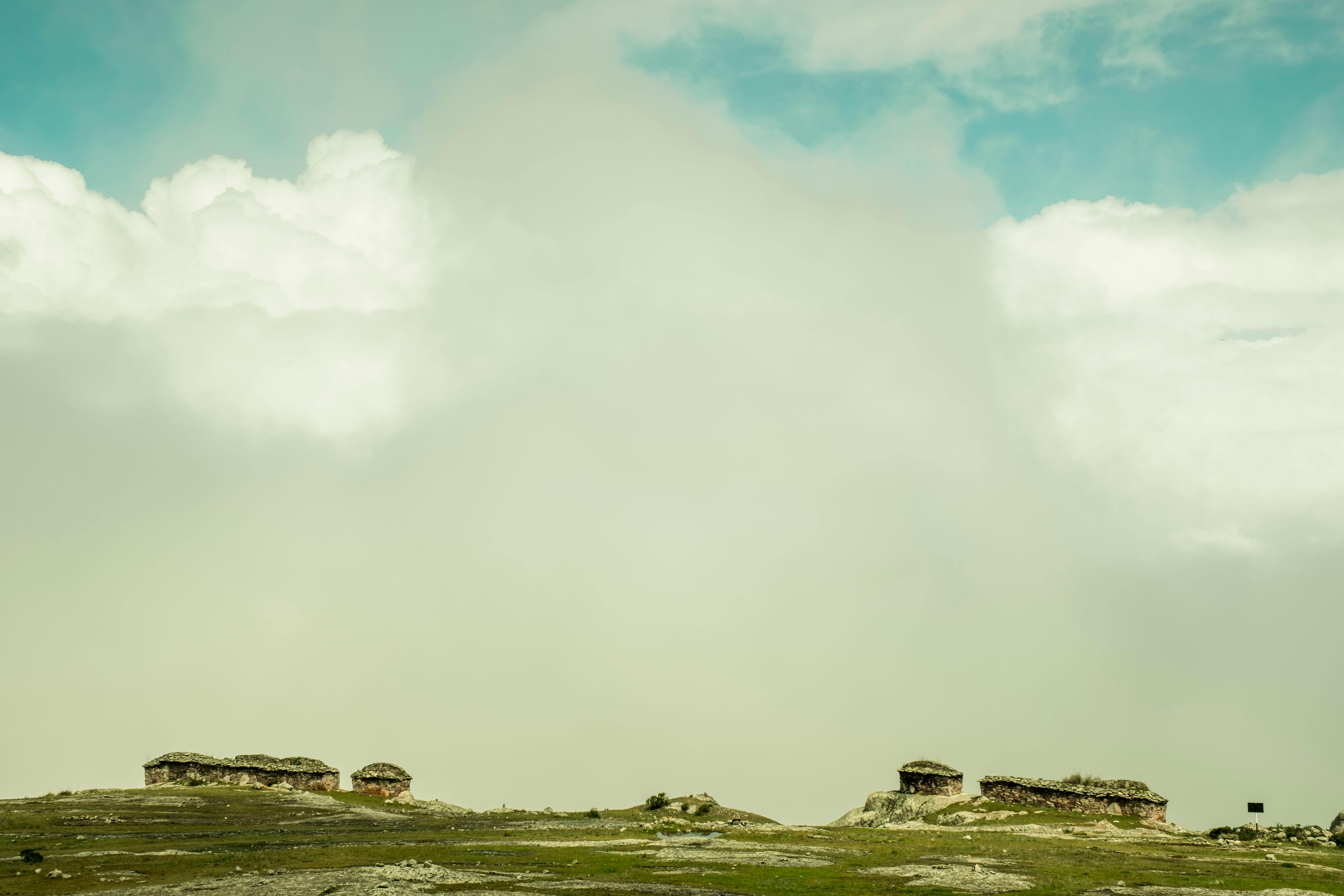 Rustic Stone Huts in Expansive Grassland · Free Stock Photo