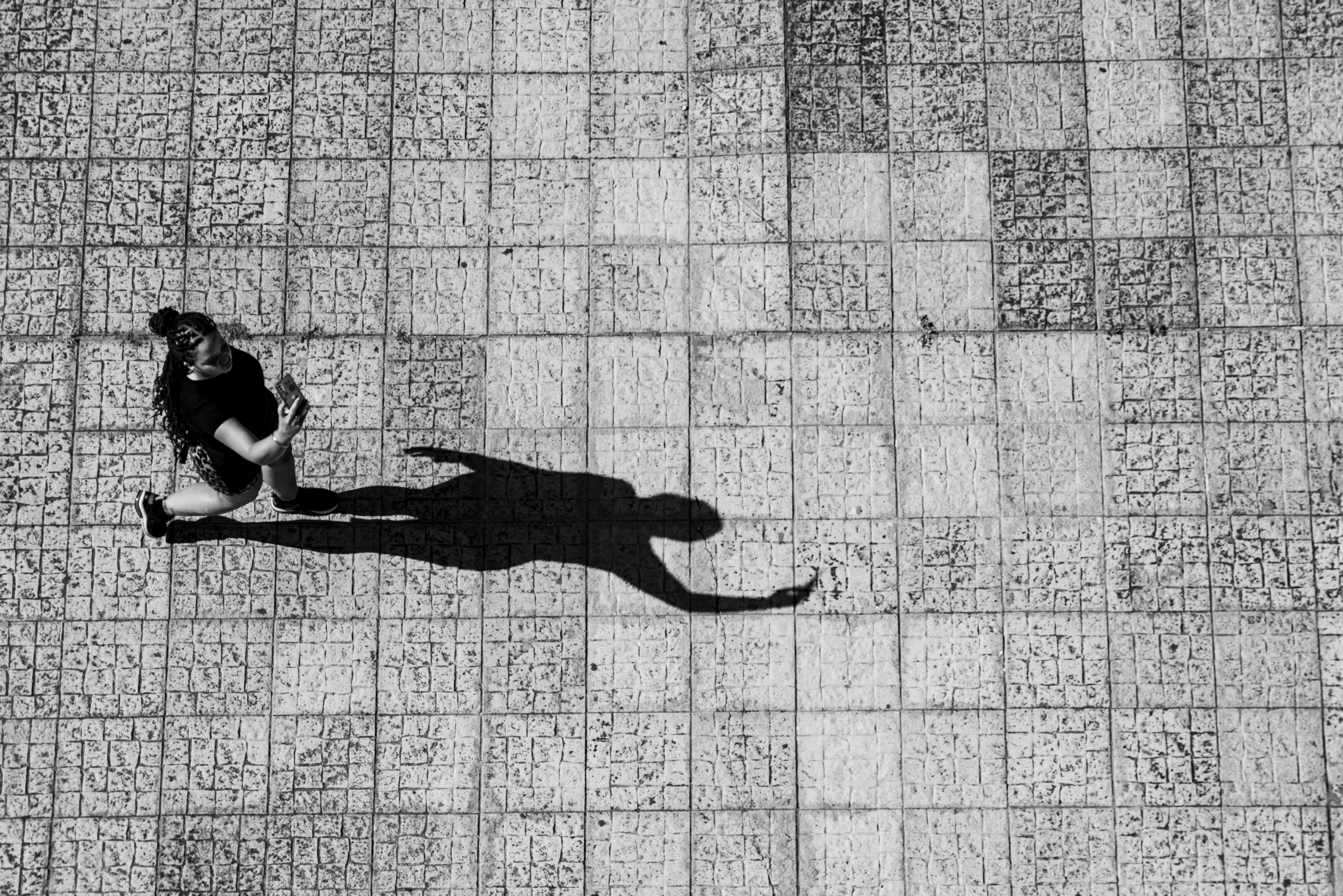 Aerial View of Person Casting a Shadow on Tiled Ground · Free Stock Photo