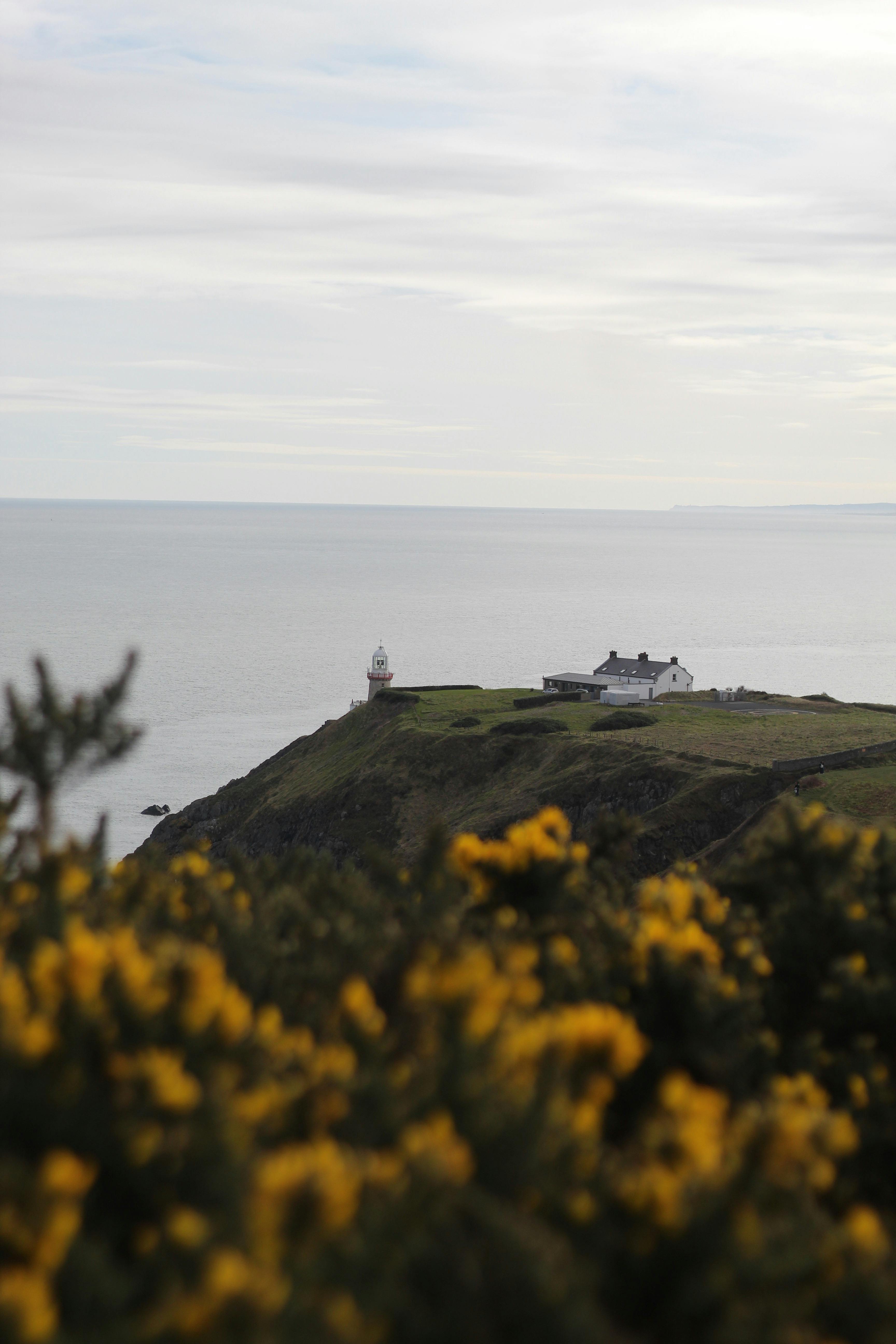 Scenic Cliffside Lighthouse Overlooking Sea · Free Stock Photo