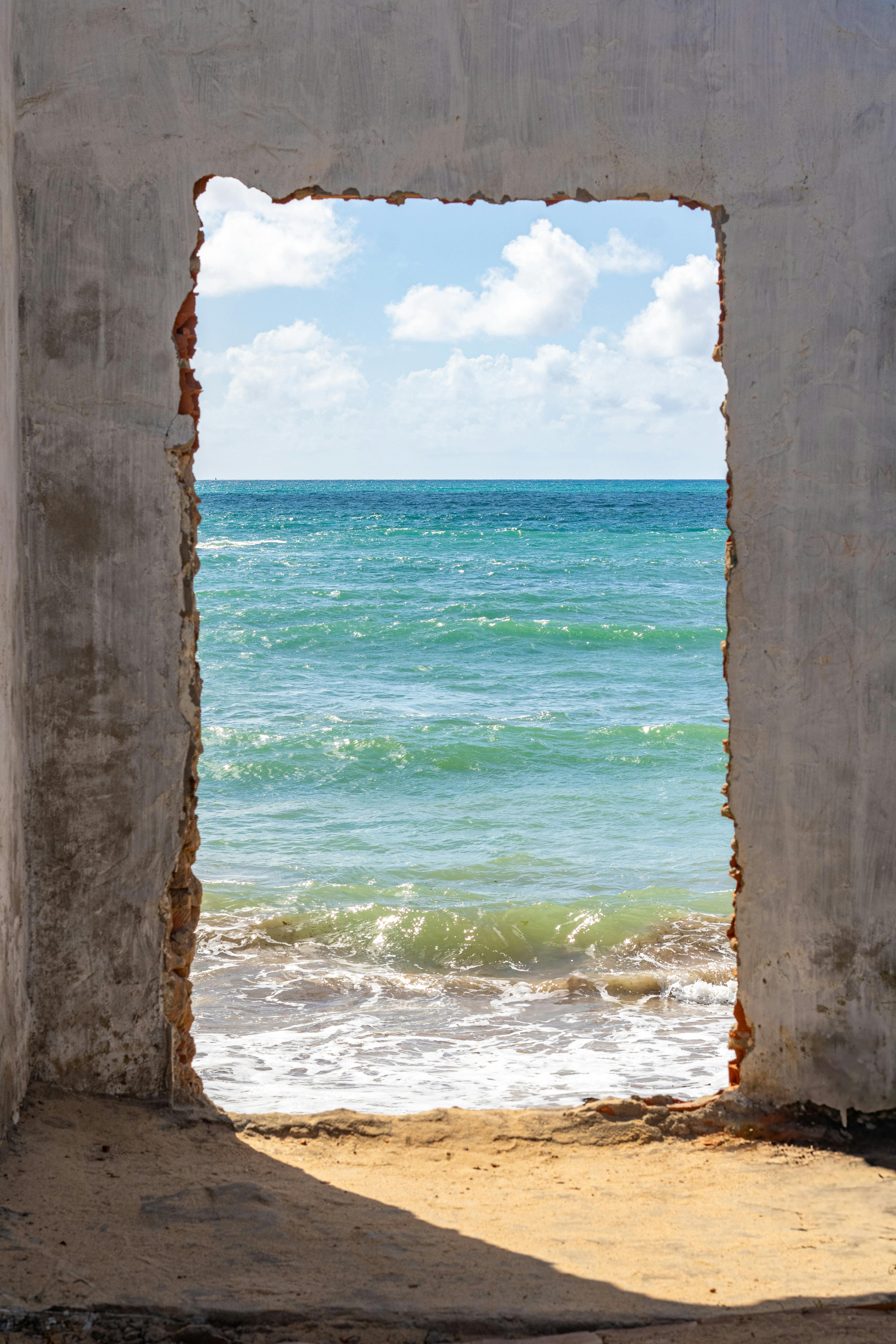 Rustic Seaside View Through Stone Wall Opening · Free Stock Photo