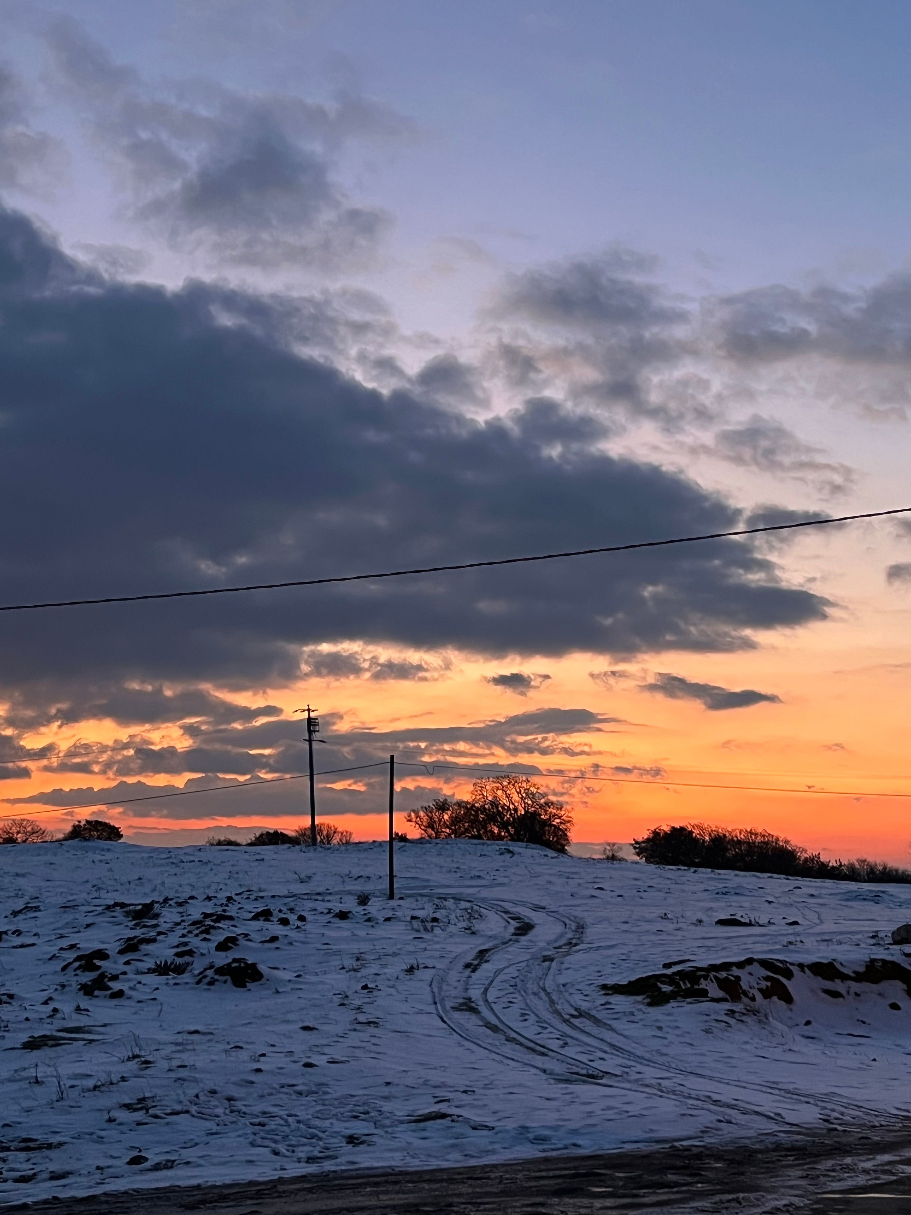 Winter Sunset Over Snowy Landscape with Tracks · Free Stock Photo