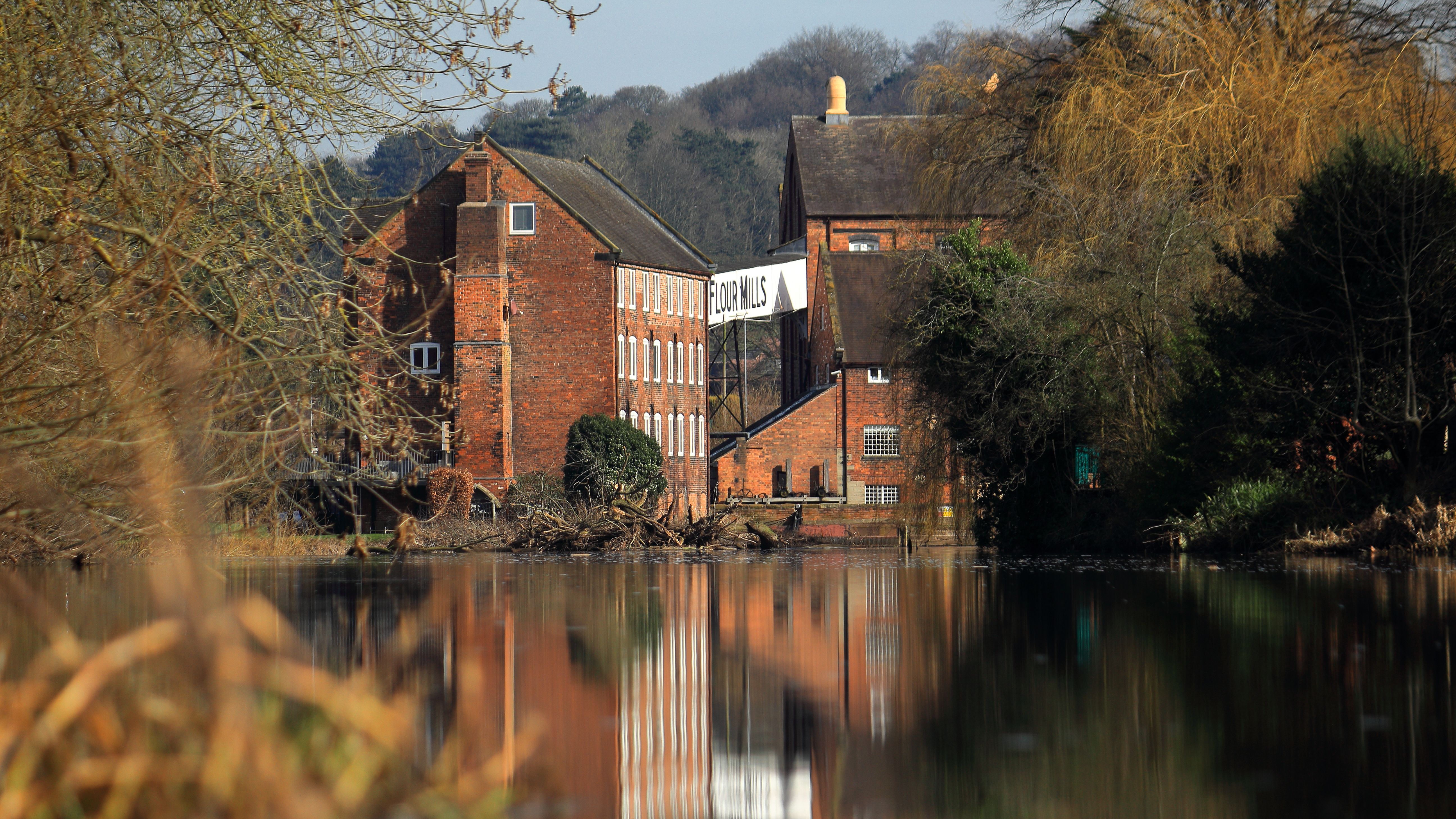 Historic Flour Mill by the River with Reflections · Free Stock Photo