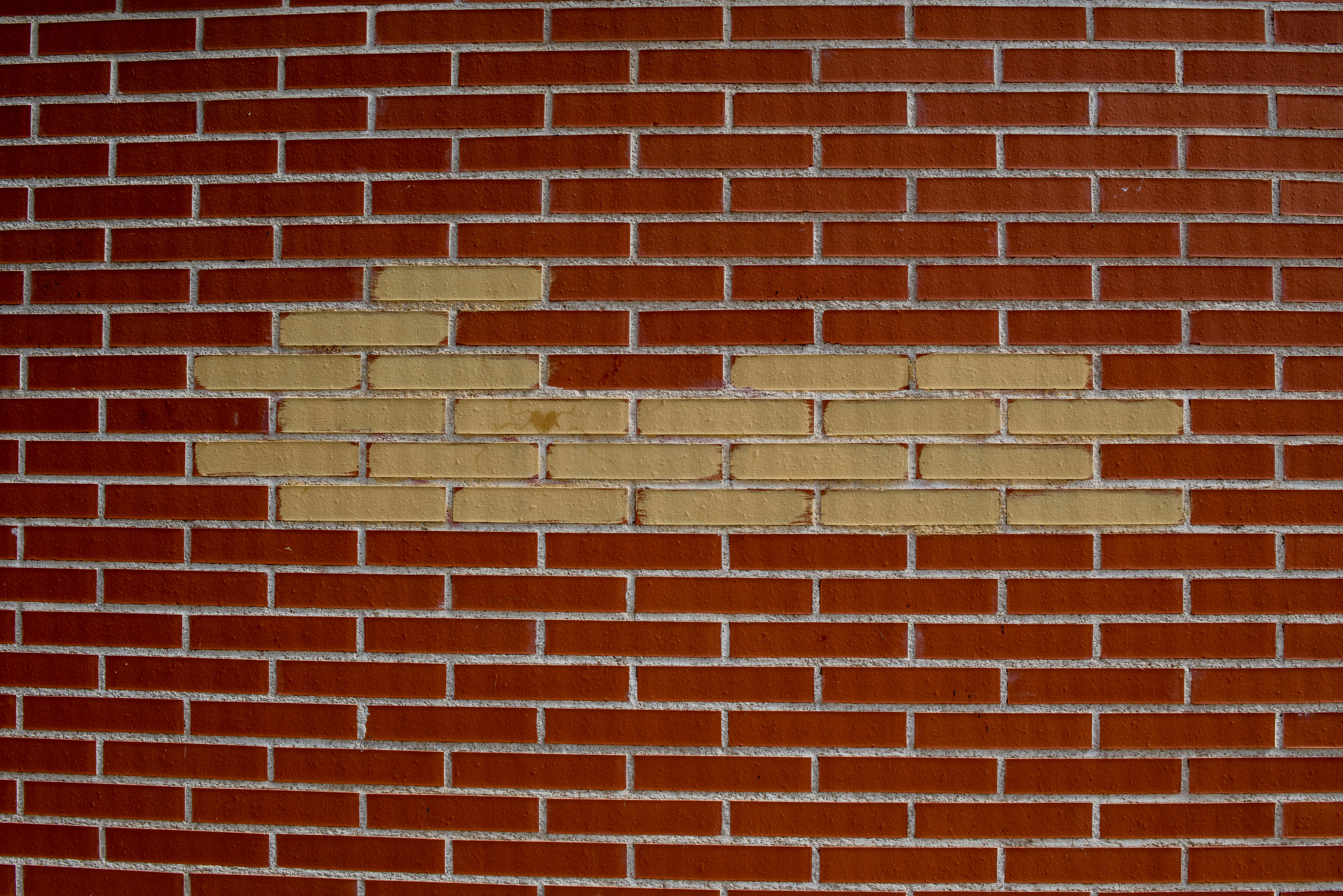 Red Brick Wall with Yellow Patch Background · Free Stock Photo