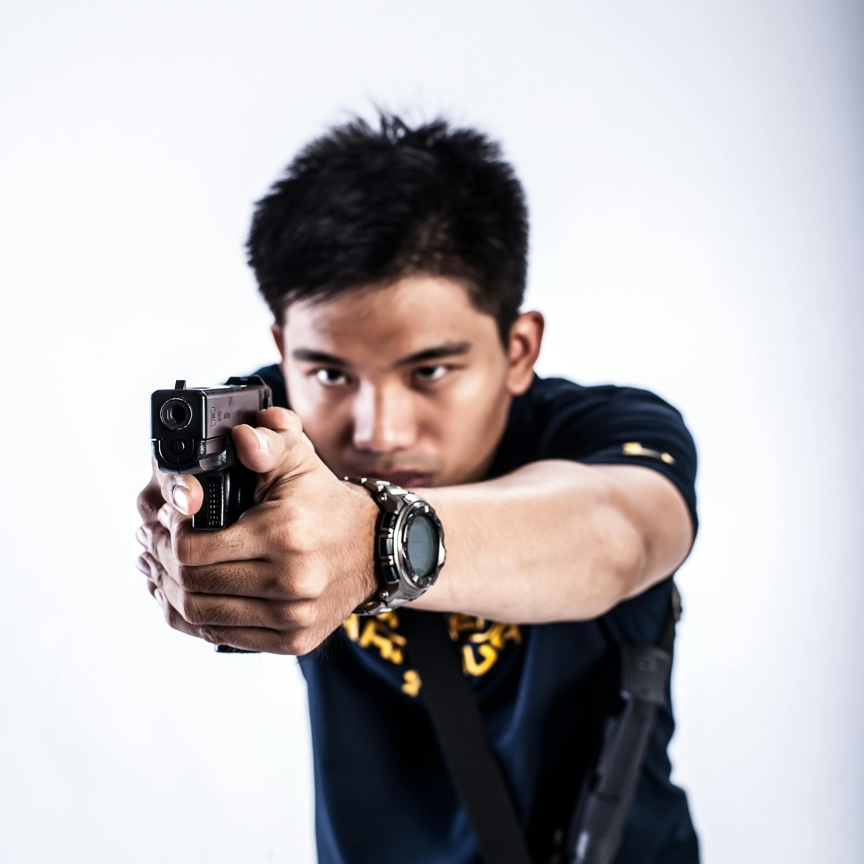 Man Holding up a Gun · Free Stock Photo