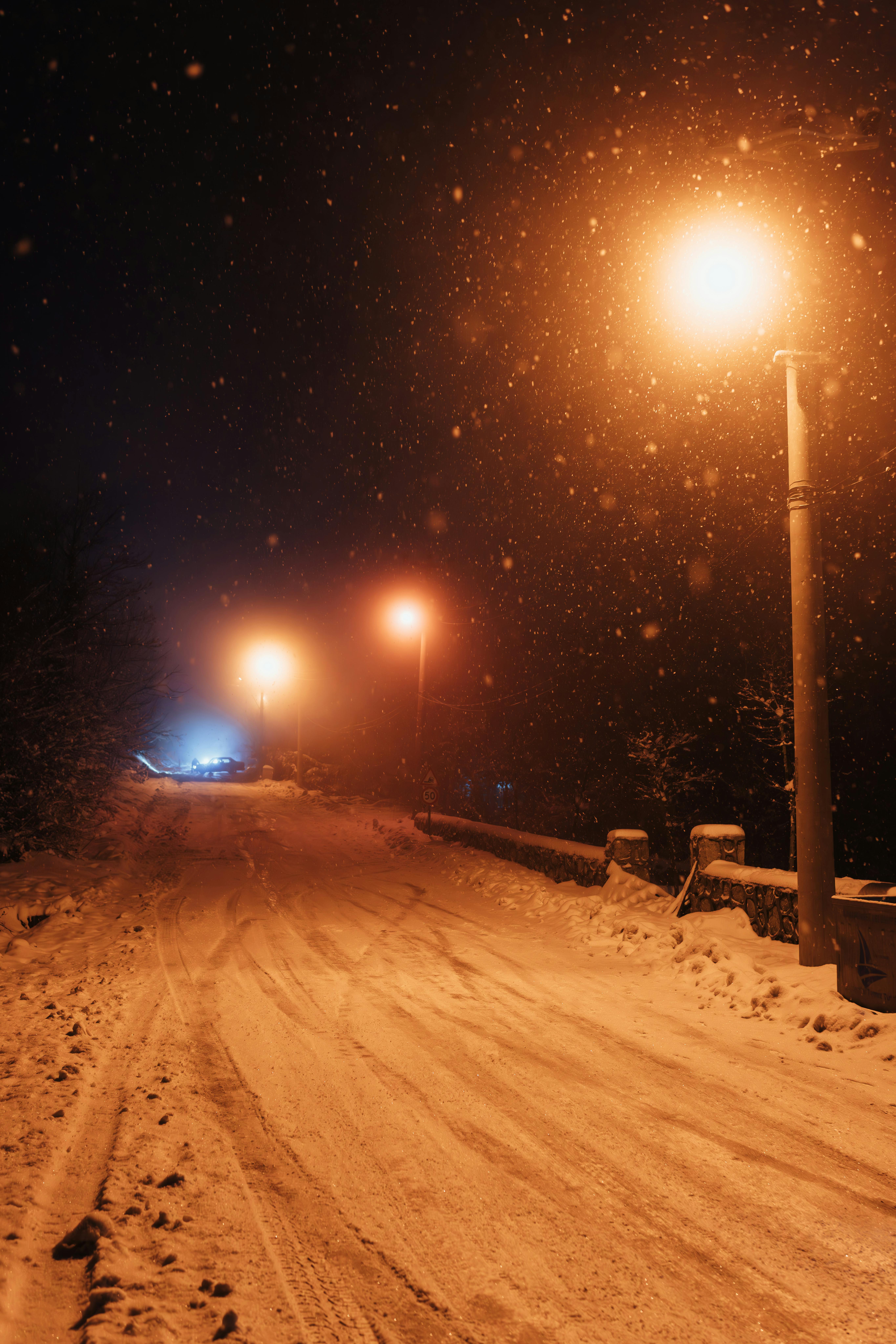 Snowy Street Under Warm Streetlights at Night · Free Stock Photo