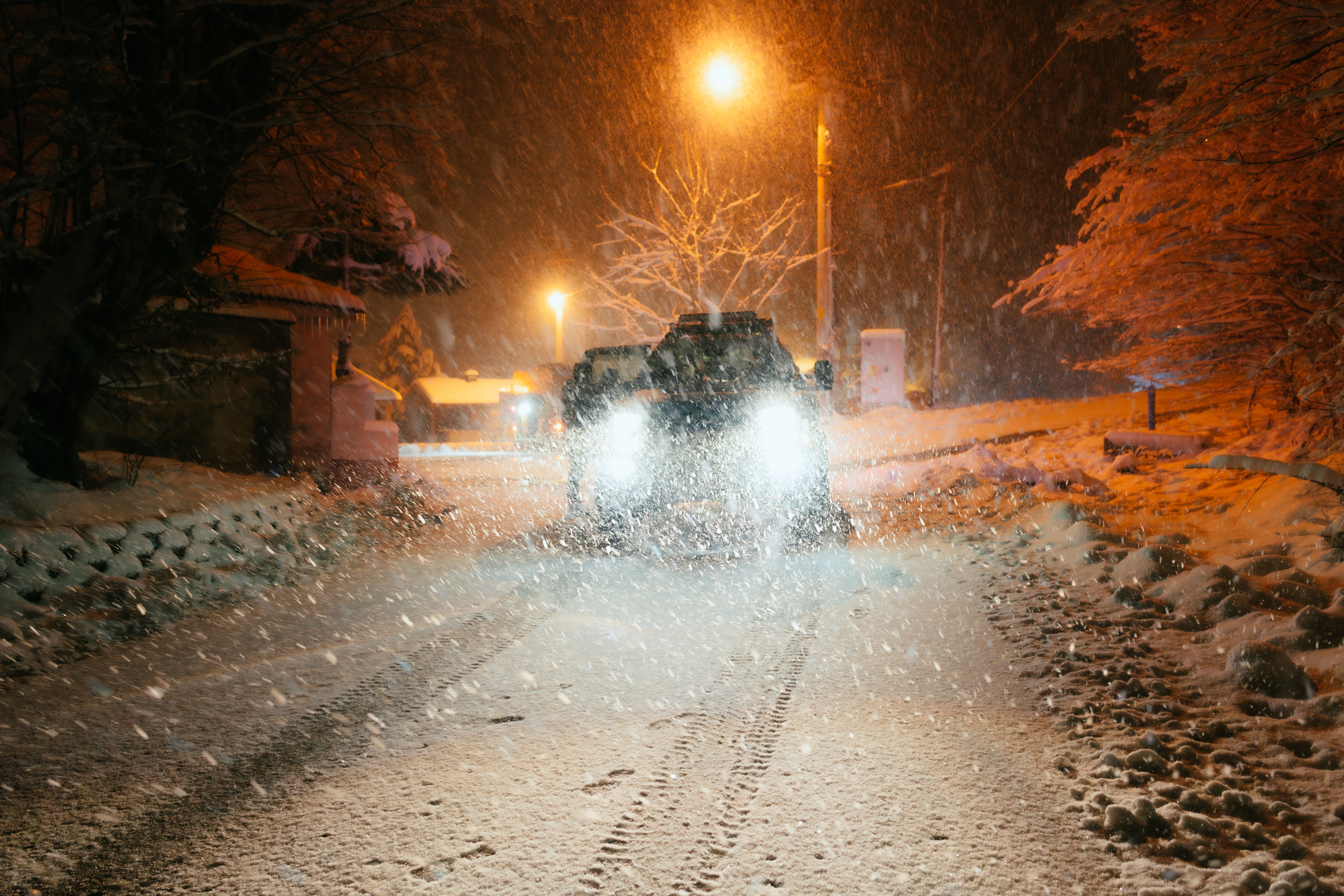 Snowy Night Drive on Illuminated Rural Road · Free Stock Photo