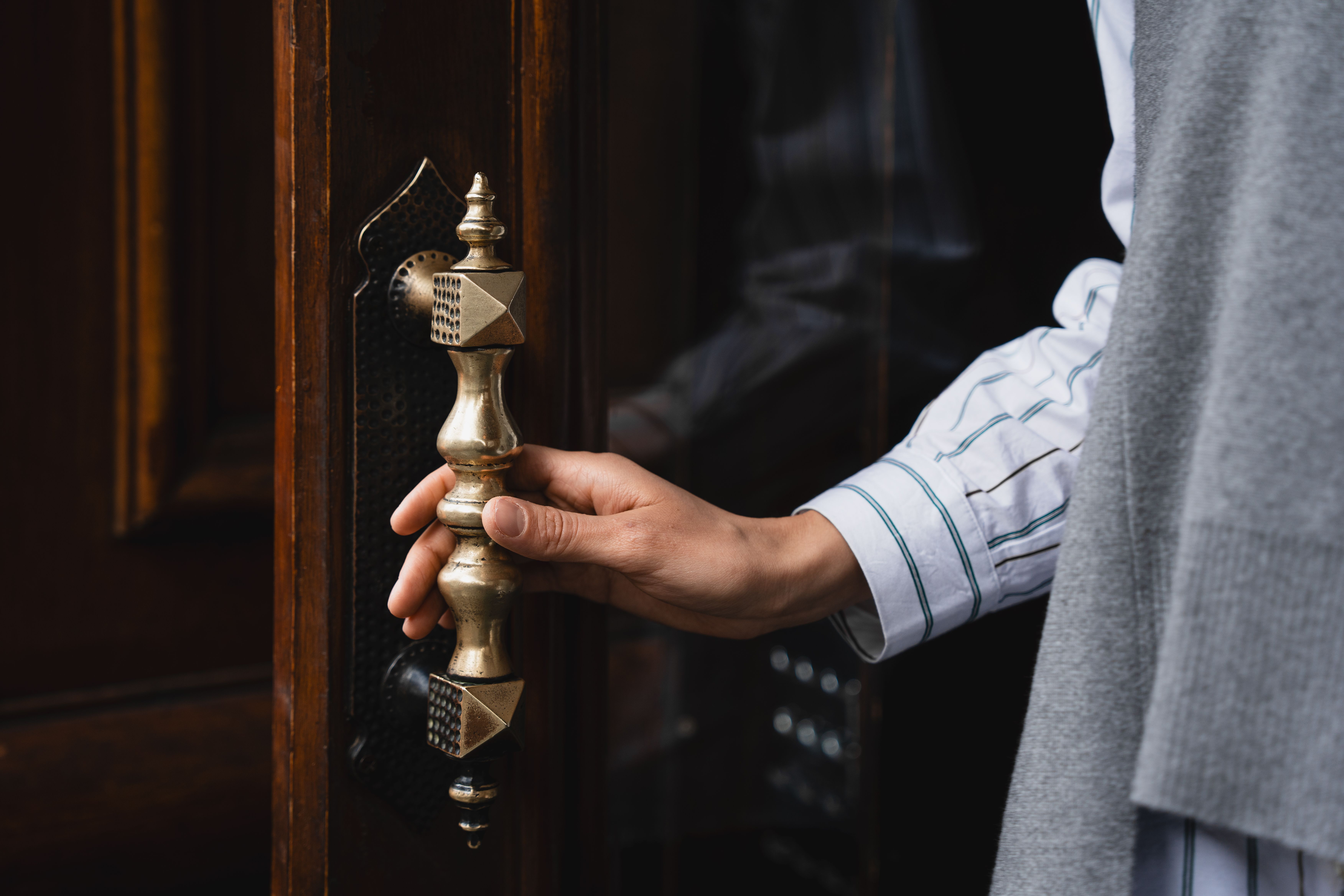Hand Turning Ornate Brass Door Handle Close-Up · Free Stock Photo