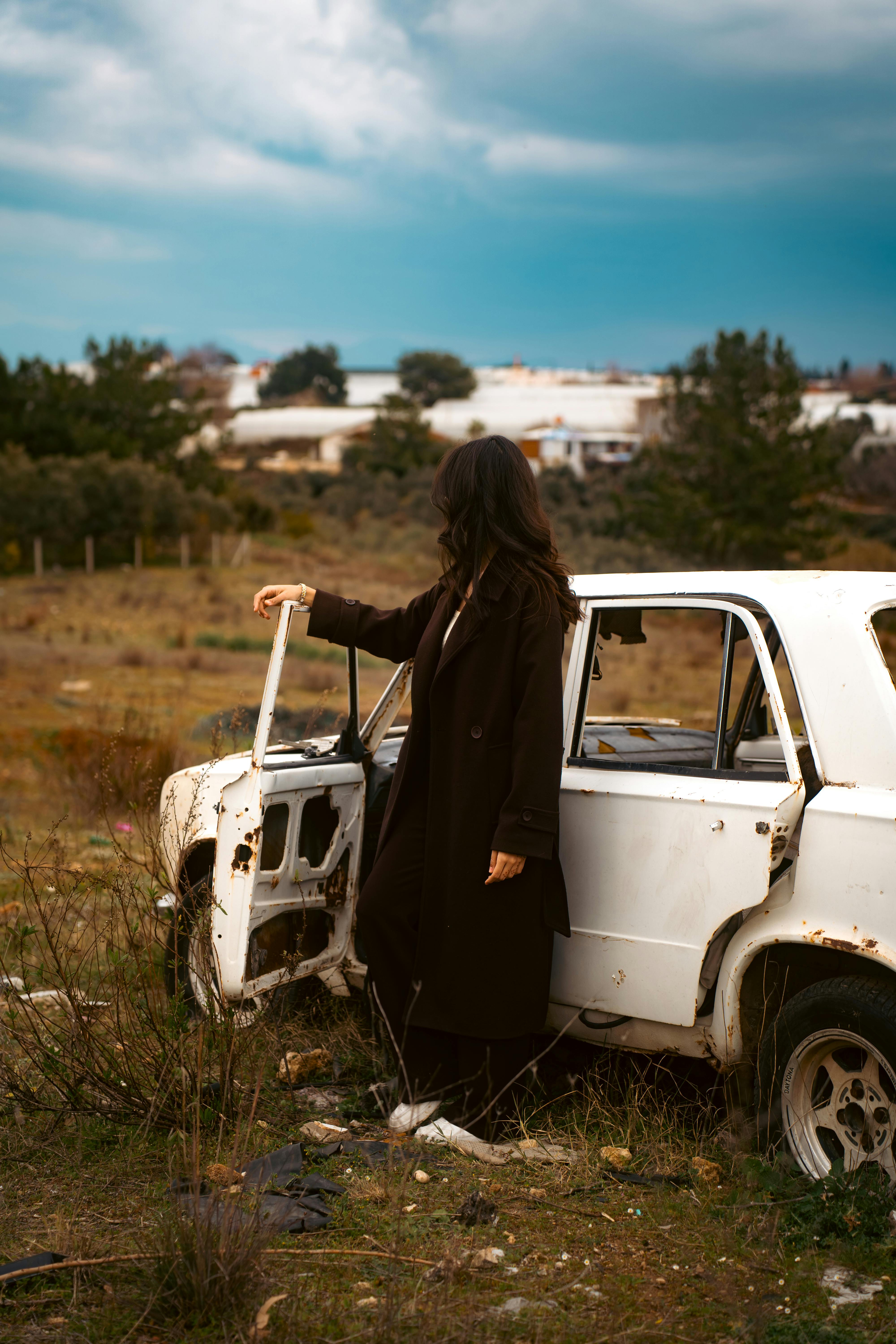 Woman with Old Rusty Car in Rural Setting · Free Stock Photo