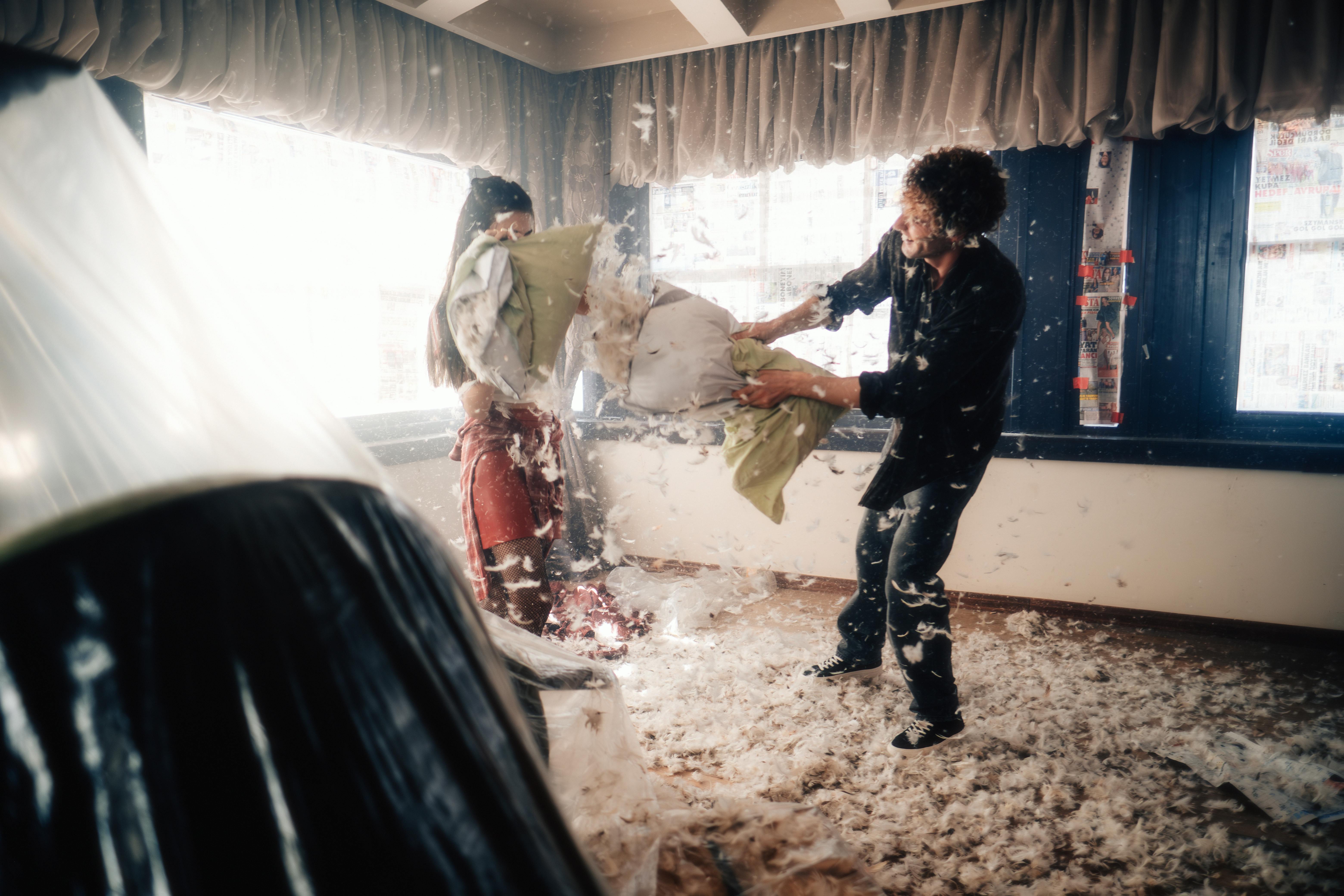 Playful Pillow Fight with Feathers Flying · Free Stock Photo