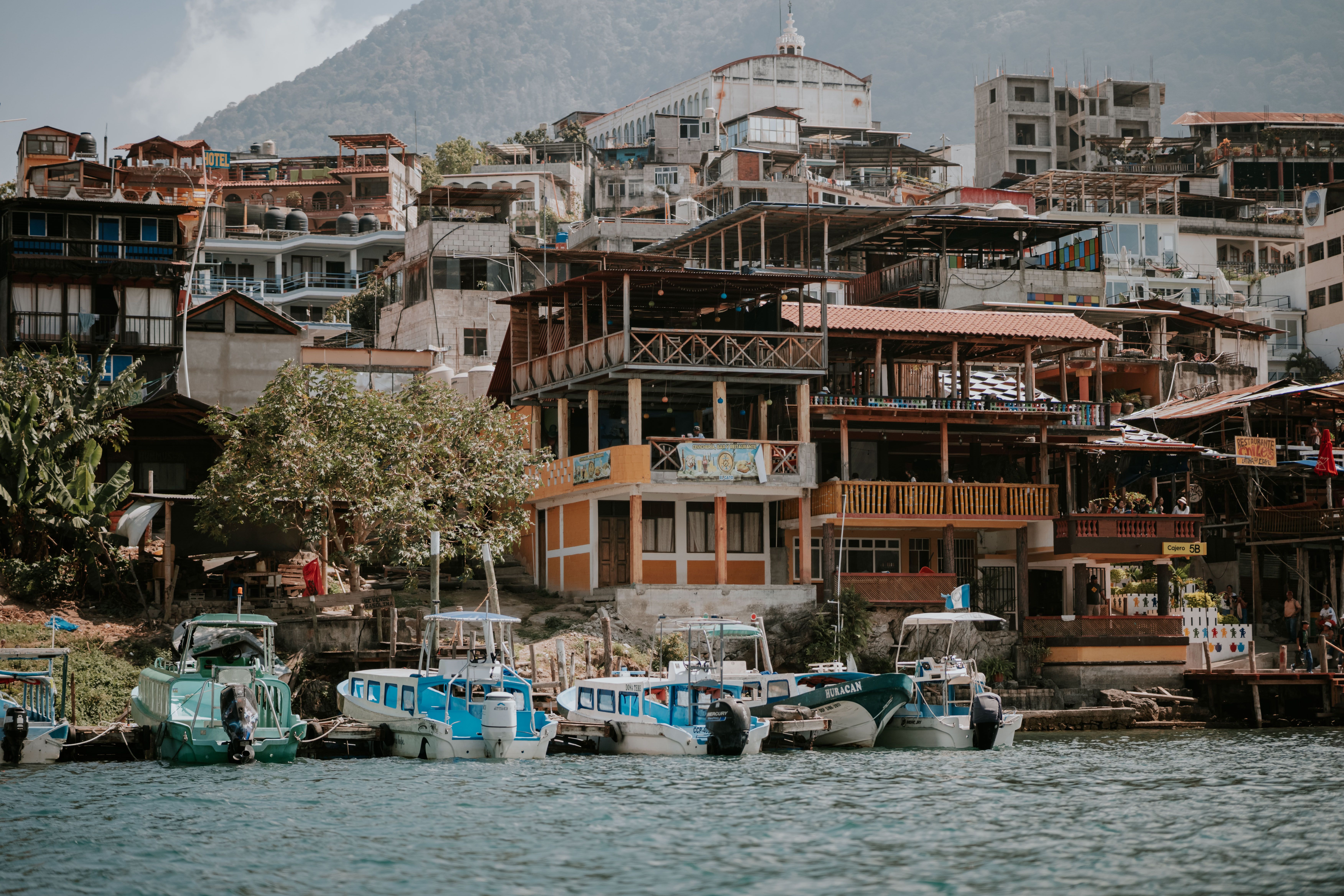 Charming Lakeside Town with Colorful Boats · Free Stock Photo