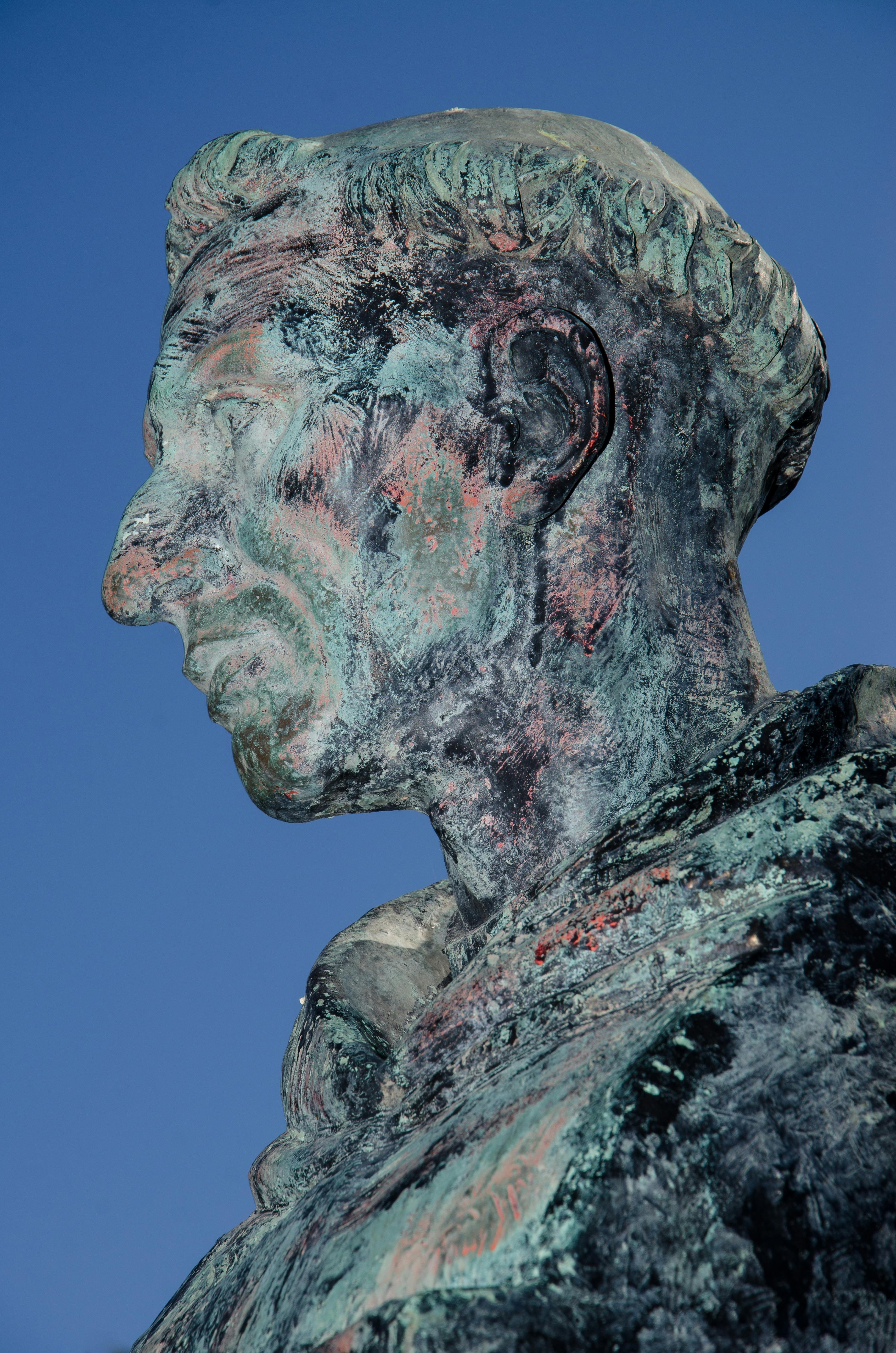 Close-up of Weathered Bronze Statue with Blue Sky · Free Stock Photo