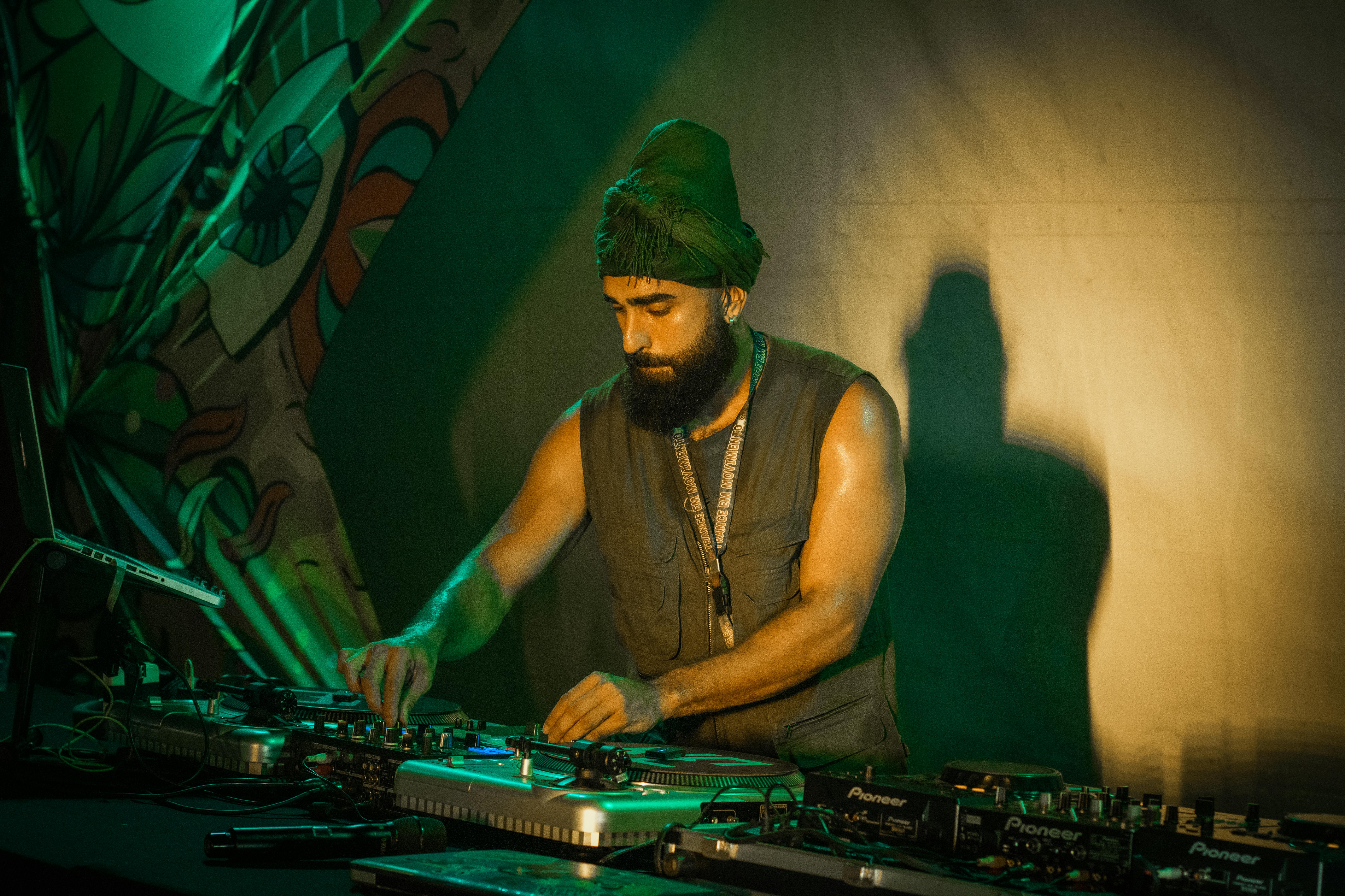 DJ Performing at Night Event with Green Lighting · Free Stock Photo