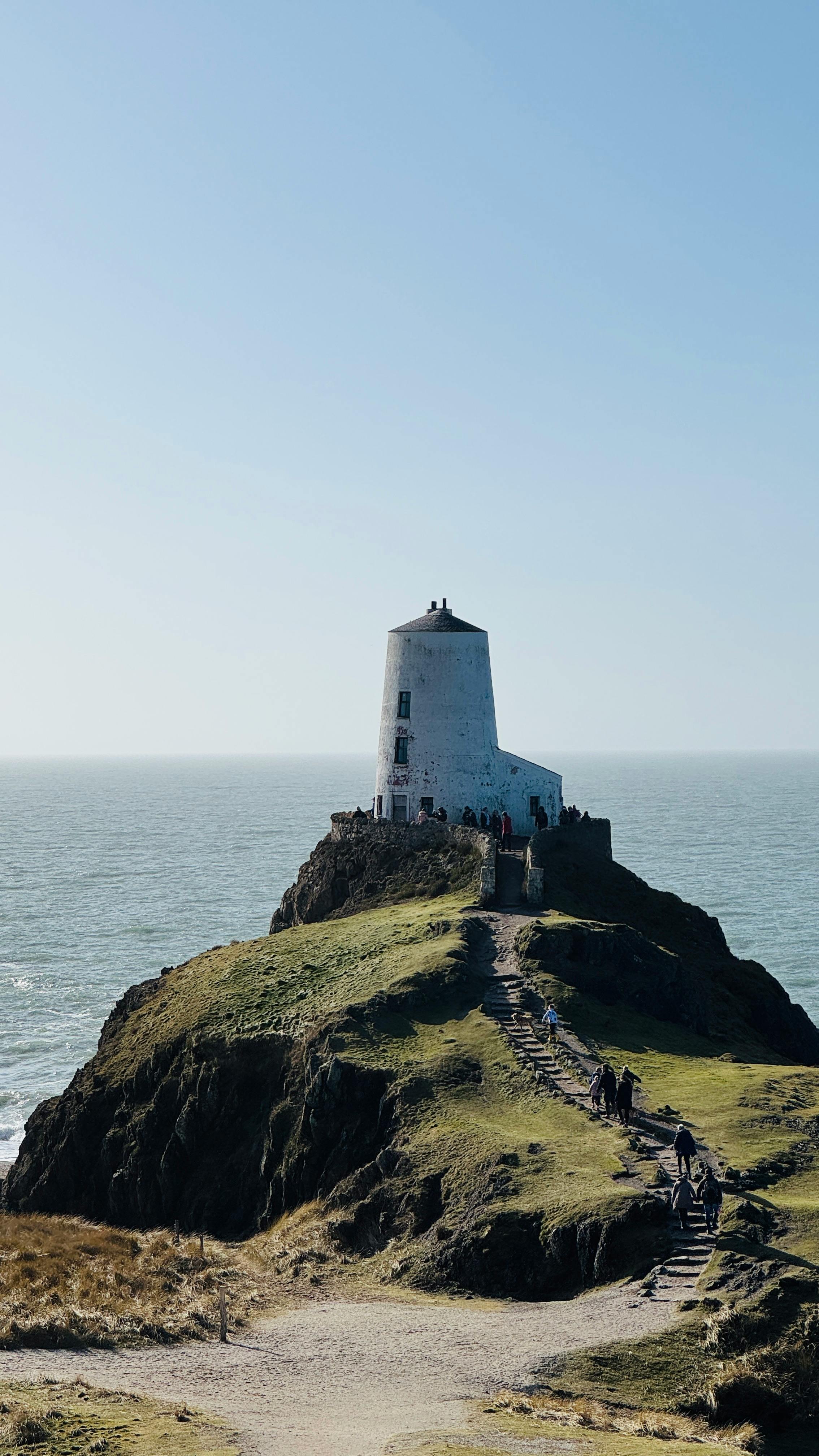Dramatic Lighthouse on Rugged Cliffside Coast · Free Stock Photo