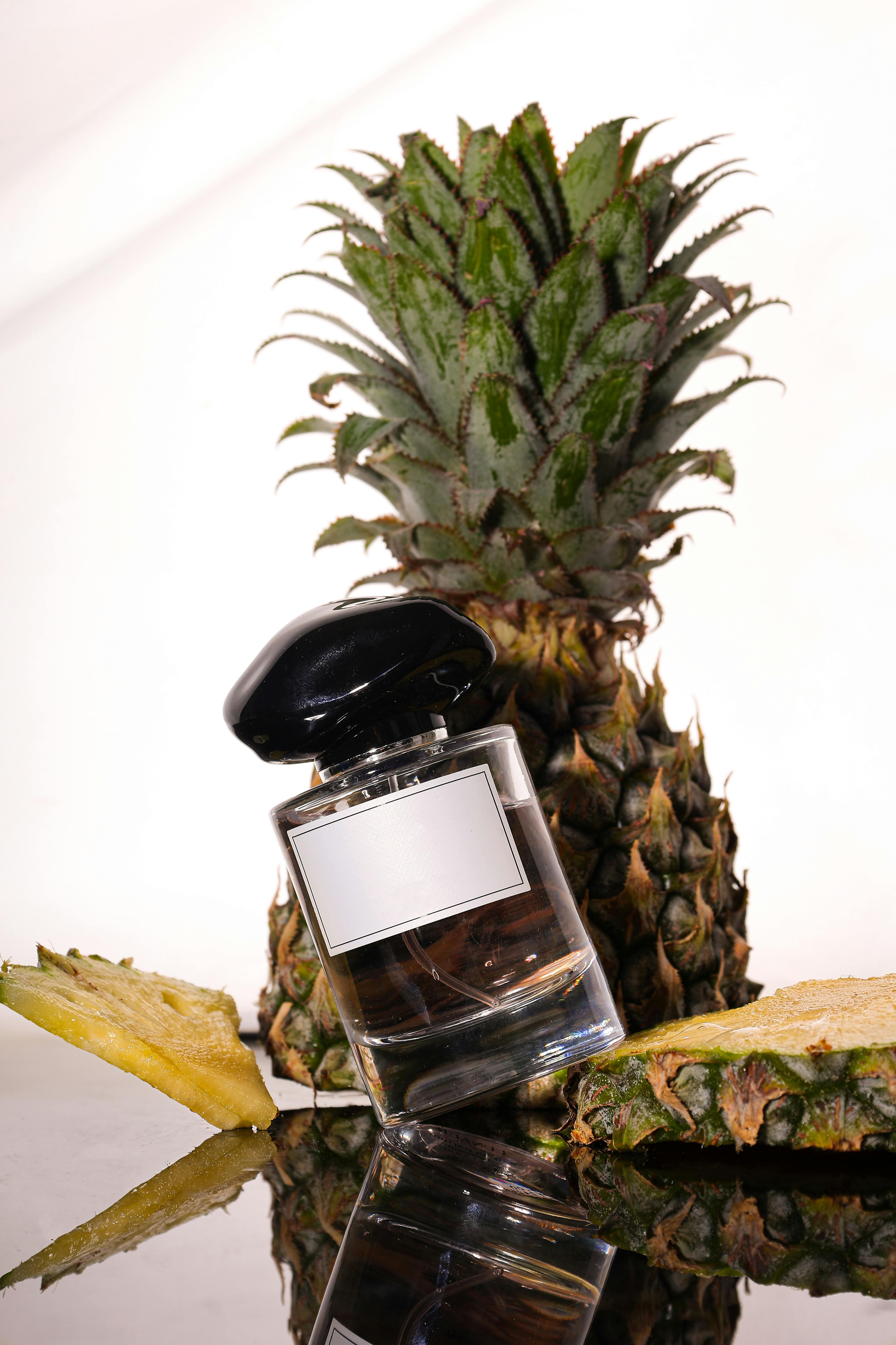 Botol Parfum Elegan Dengan Latar Belakang Nanas · Foto Stok Gratis