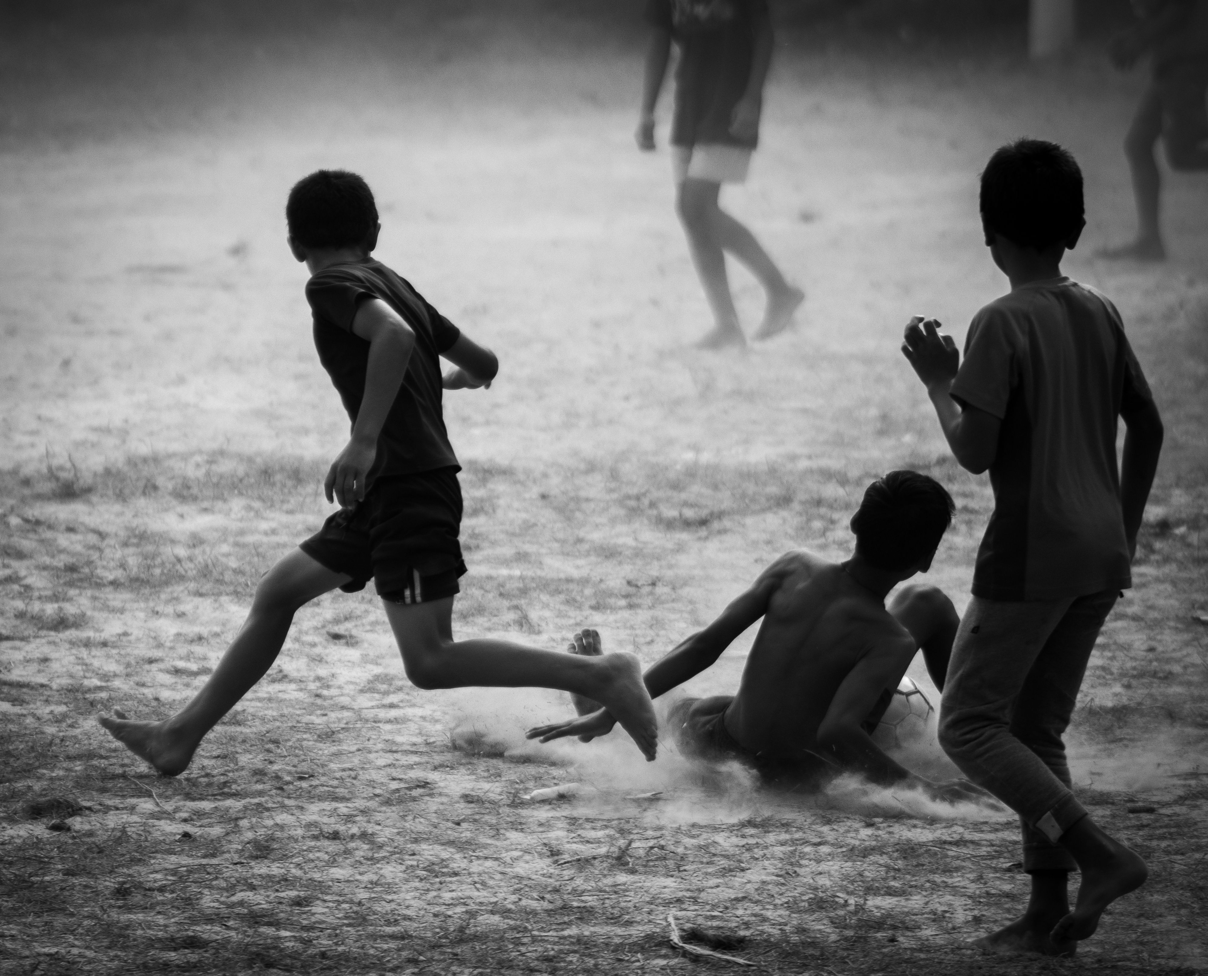 Black and White Scene of Kids Playing Football Outdoors · Free Stock Photo