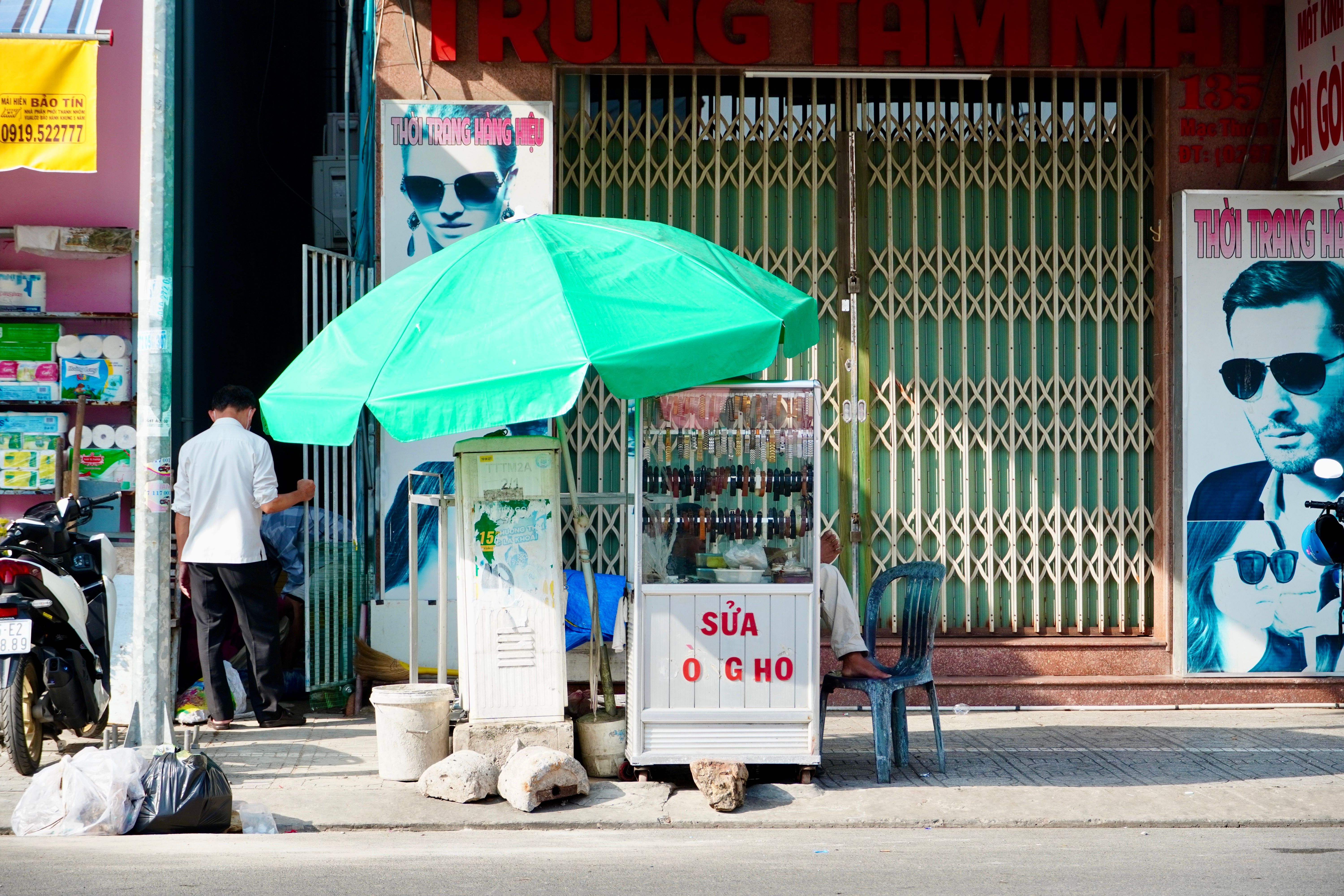 Street Vendor Stall with Green Umbrella in Urban Market · Free Stock Photo