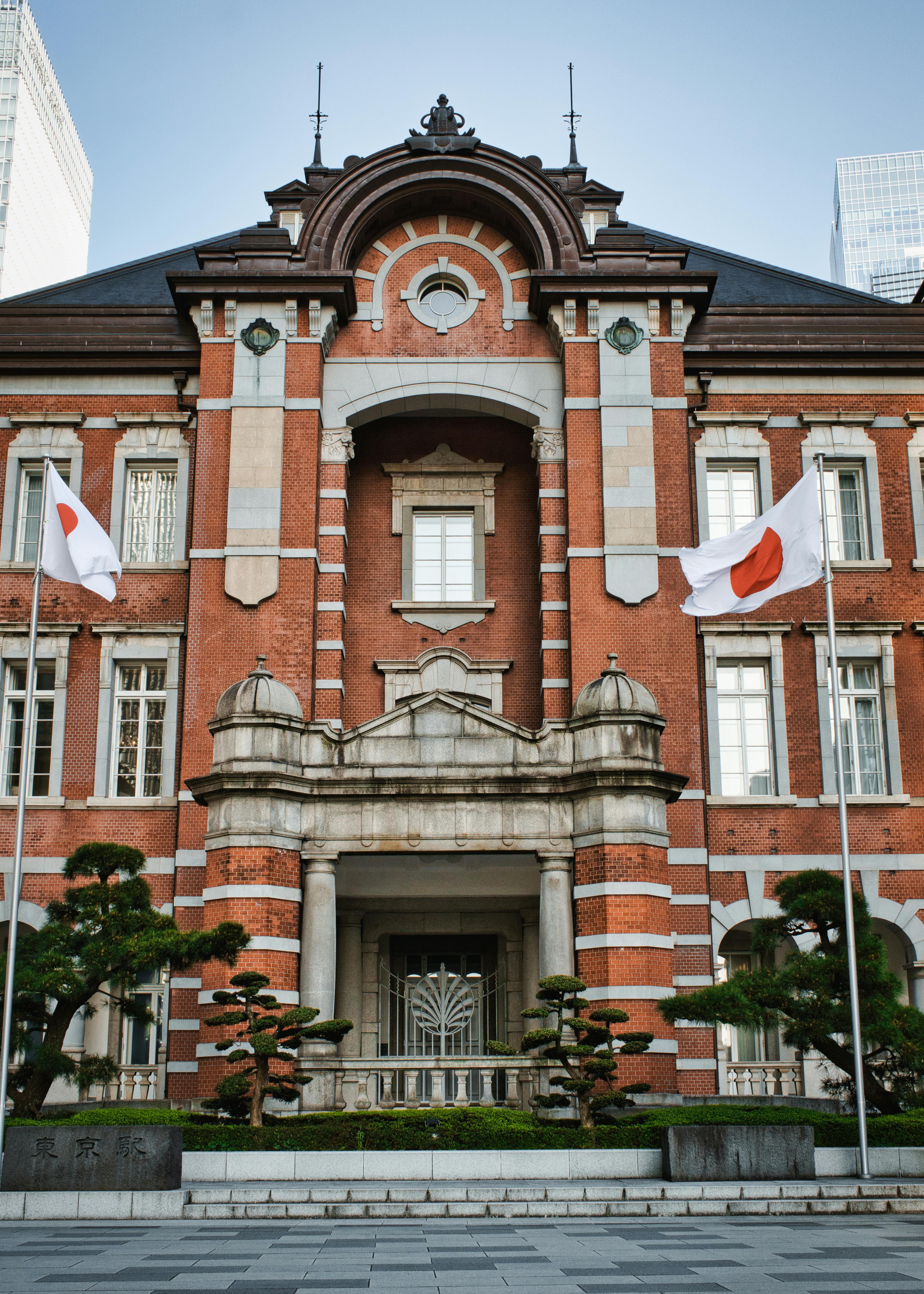 Tokyo Station Brick Facade with Japanese Flags · Free Stock Photo