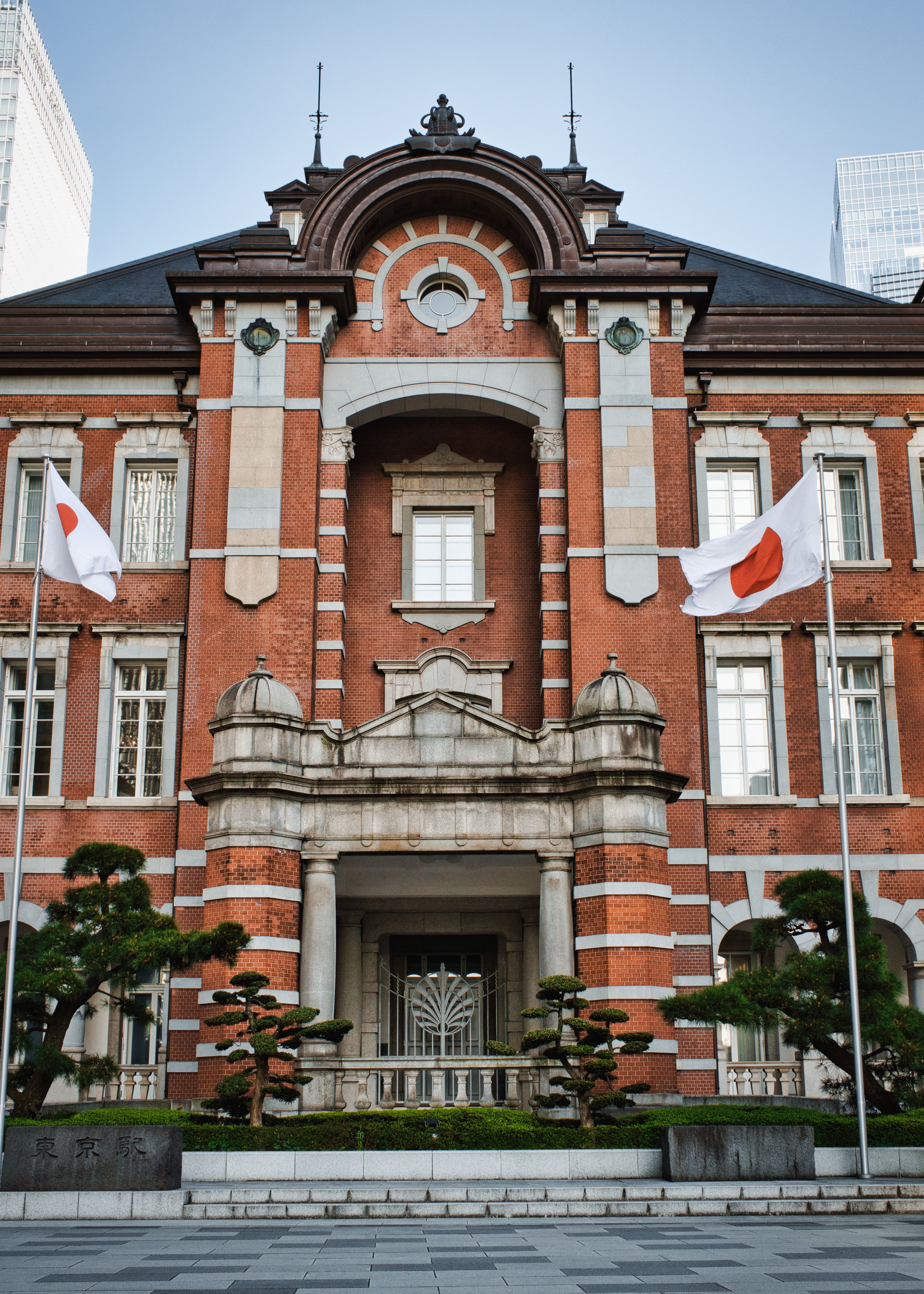 Tokyo Station Brick Facade with Japanese Flags · Free Stock Photo