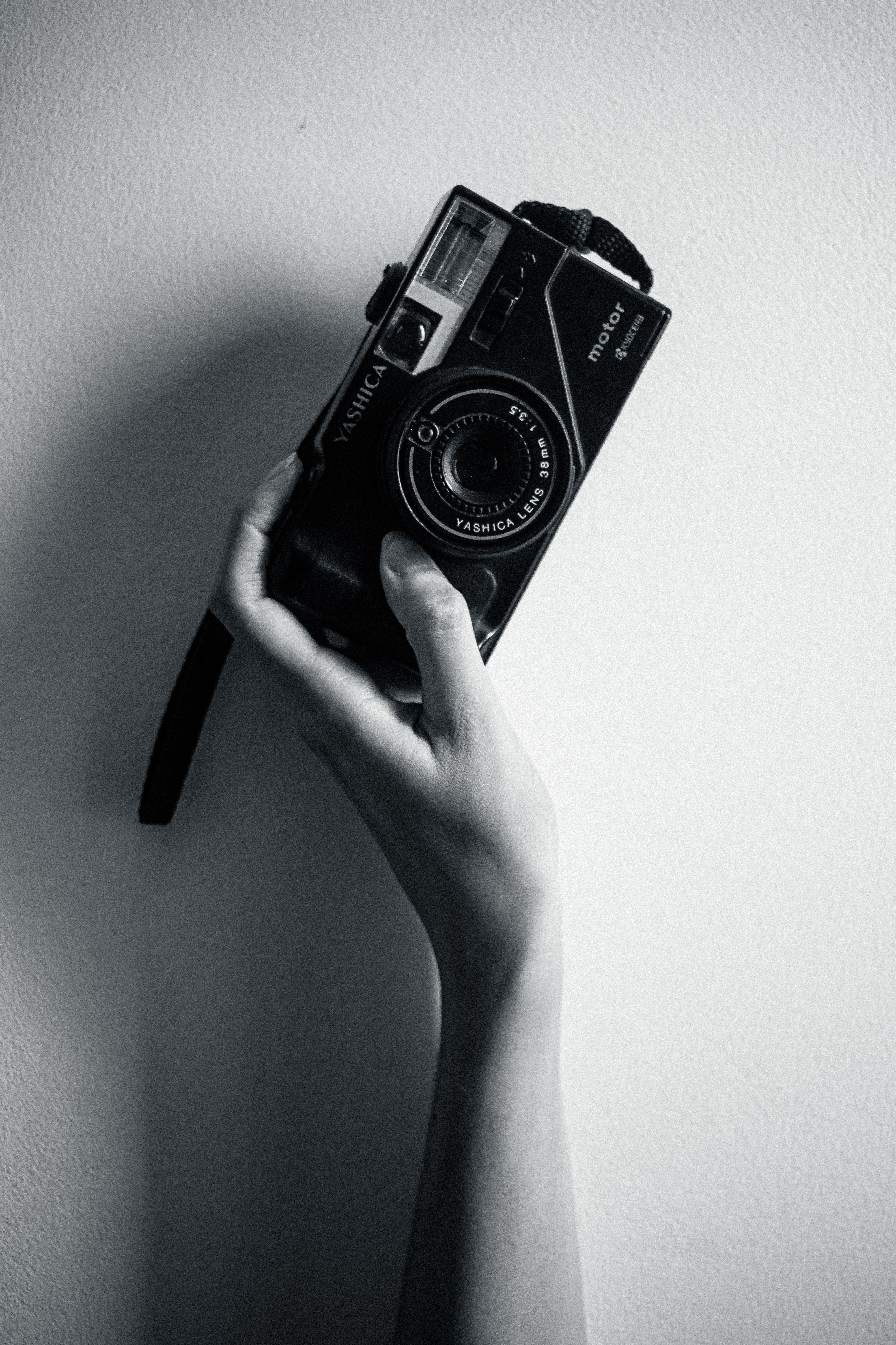 Vintage Camera in Hand Against White Wall · Free Stock Photo