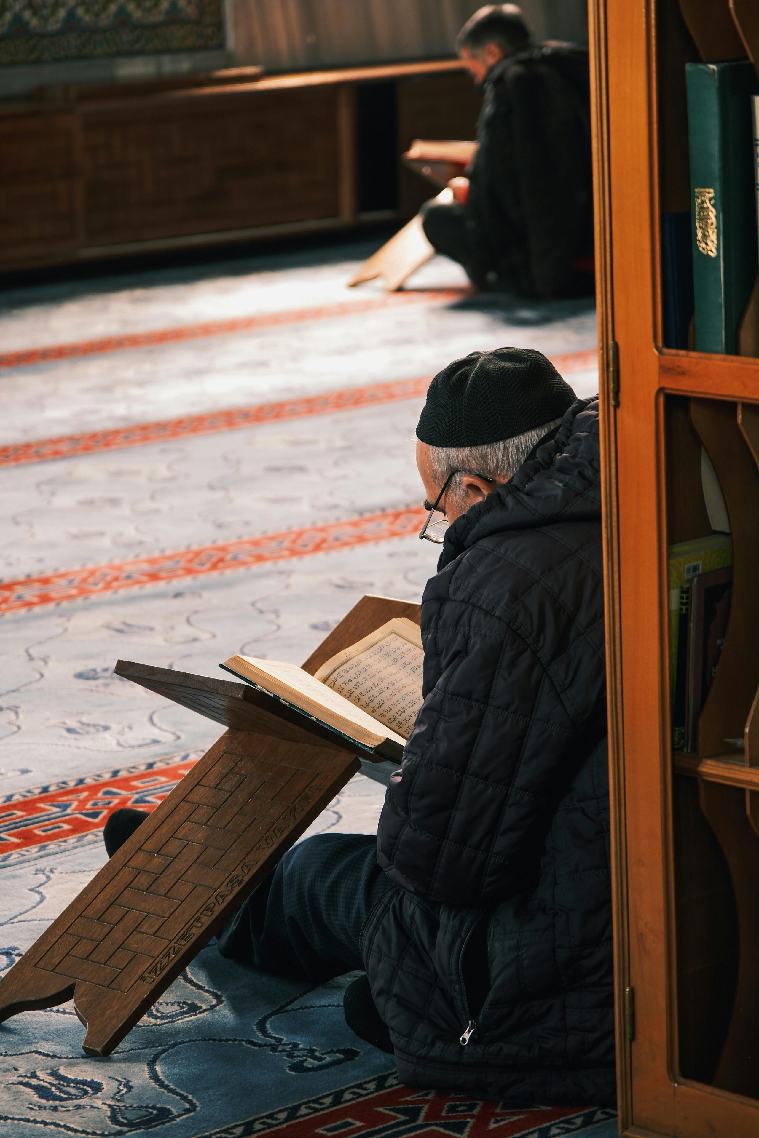 Man Reading Quran in a Peaceful Mosque Setting · Free Stock Photo