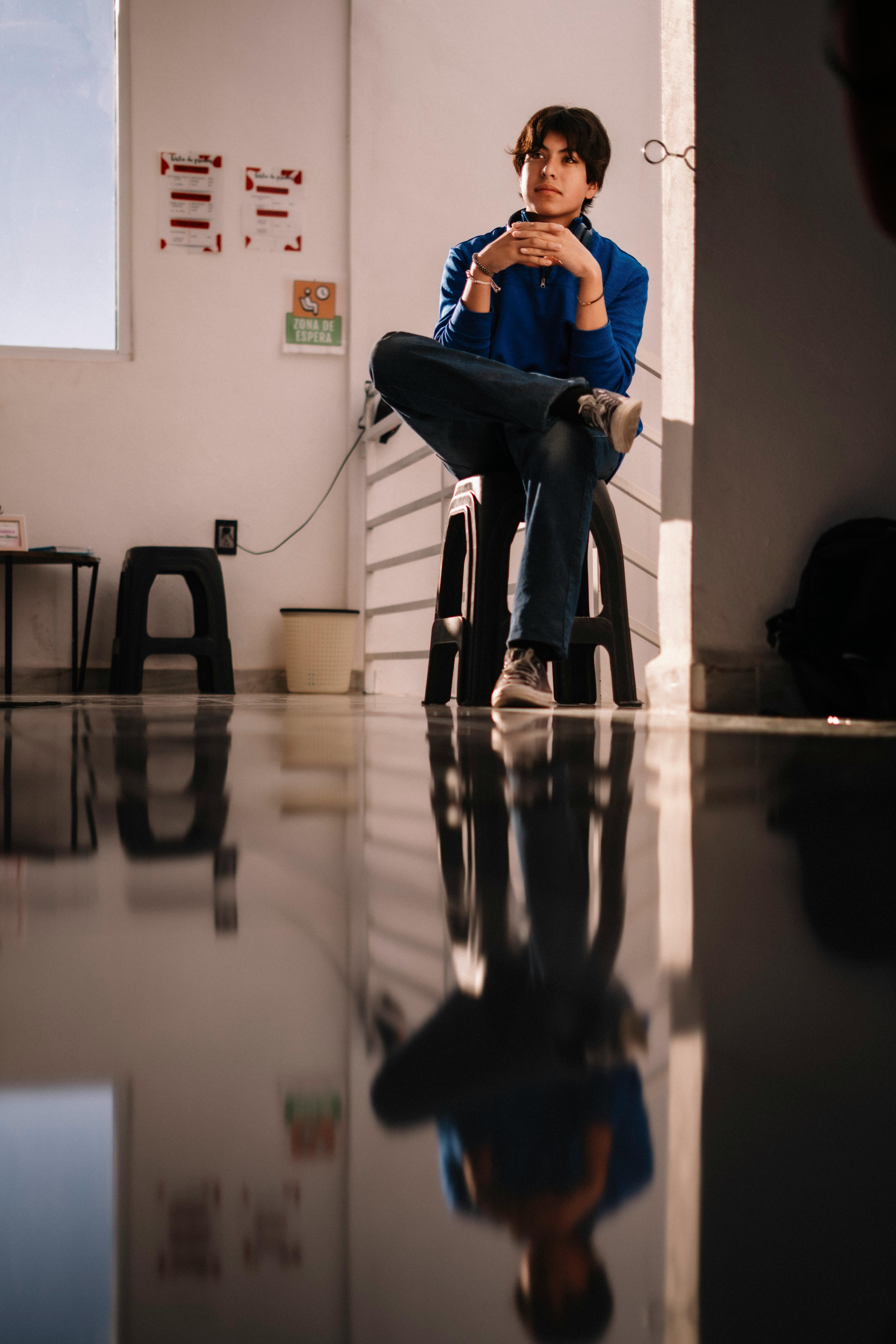 Young Man Reflecting Indoors with Dramatic Lighting · Free Stock Photo