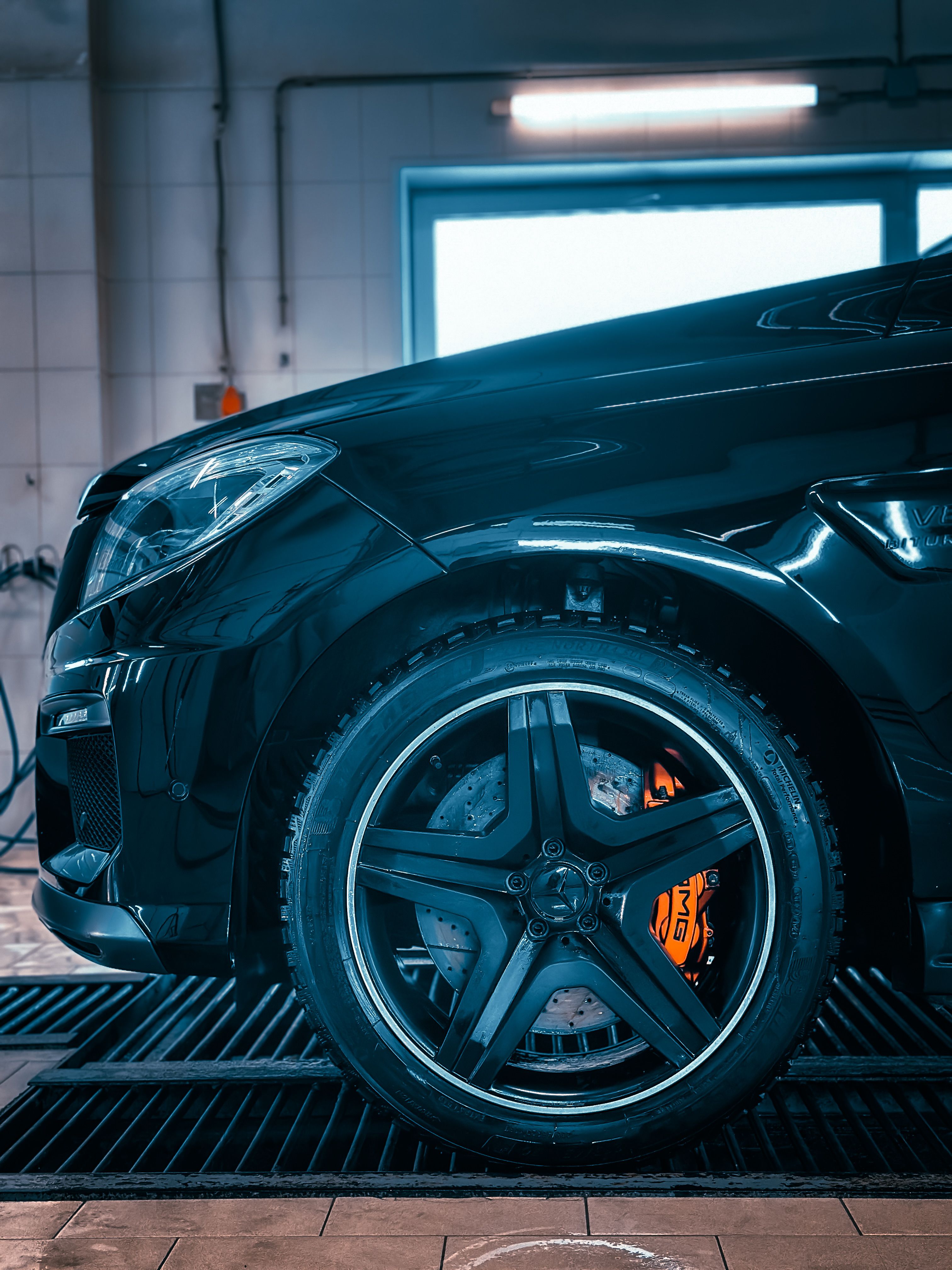Close-Up of Luxury Car Alloy Wheel in Garage Setting · Free Stock Photo